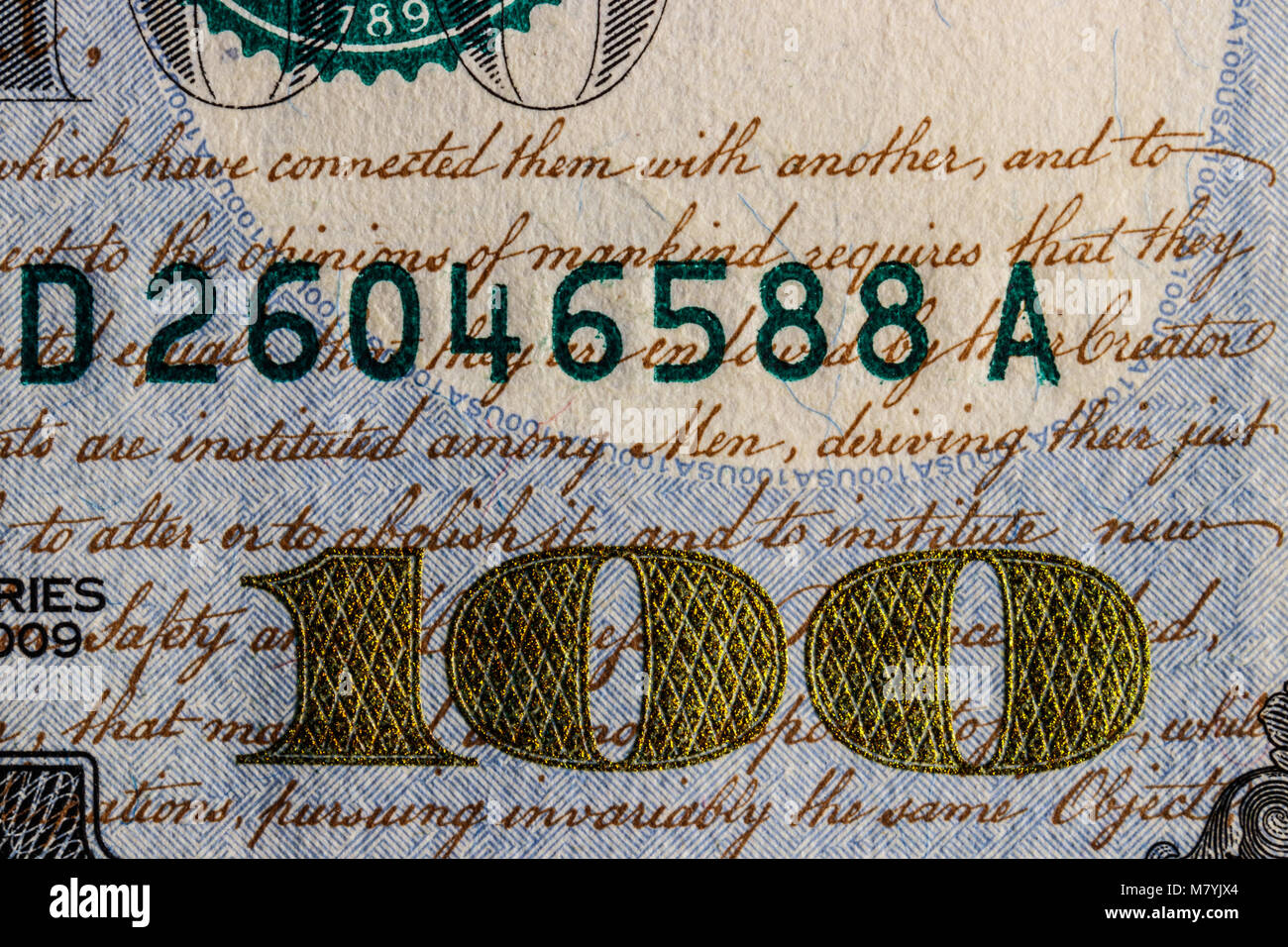 Closeup of the golden 100 and script on a one hundred dollar bill for ...