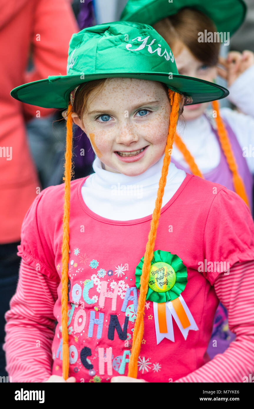 Portrait of smiling girl in a hat with her face painted in the colours ...