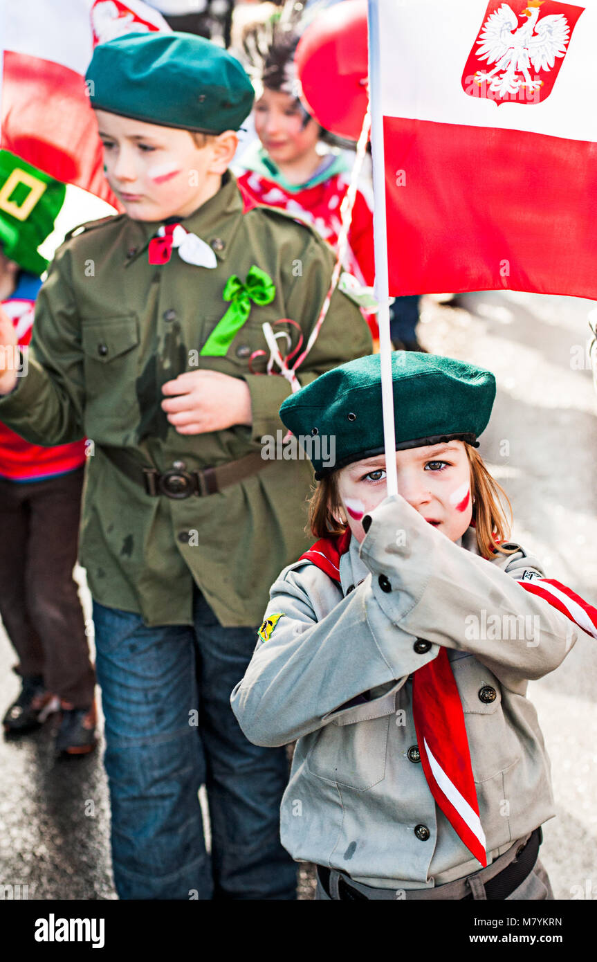 A small Polish scouting girl marches and holds the Polish flag during ...