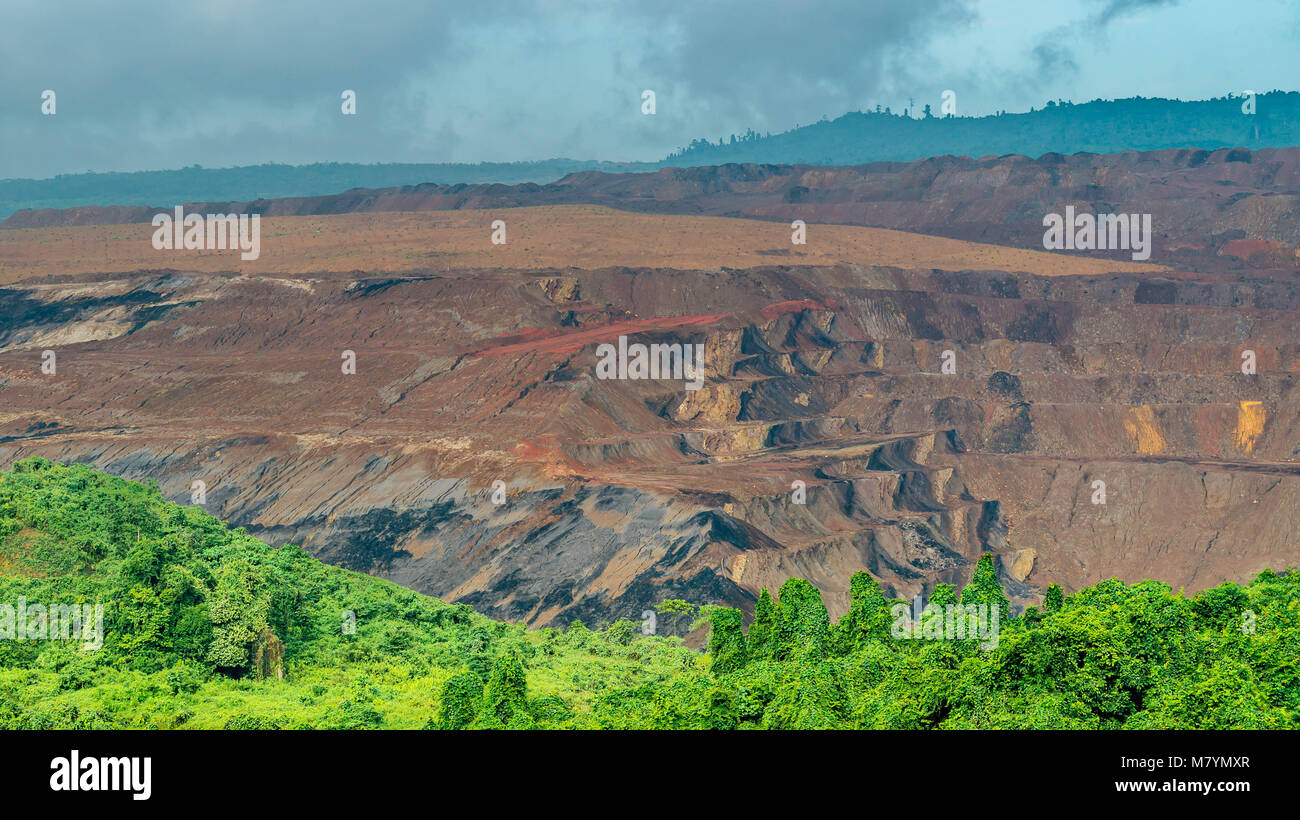 Open pit coal mining in Sangatta, Indonesia with green vegetation as ...
