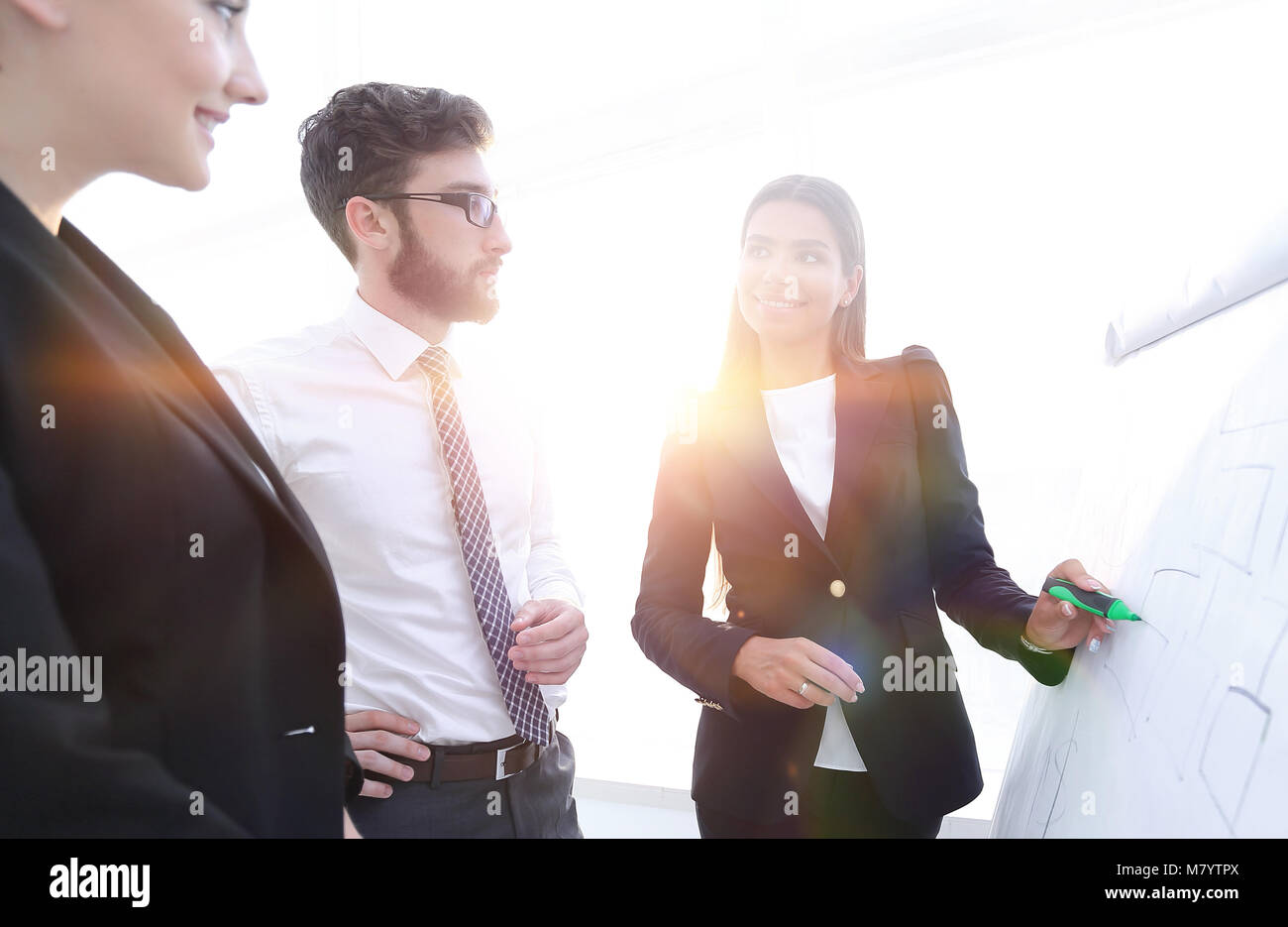 businesswoman pointing marker to flipboard on presentation in office ...