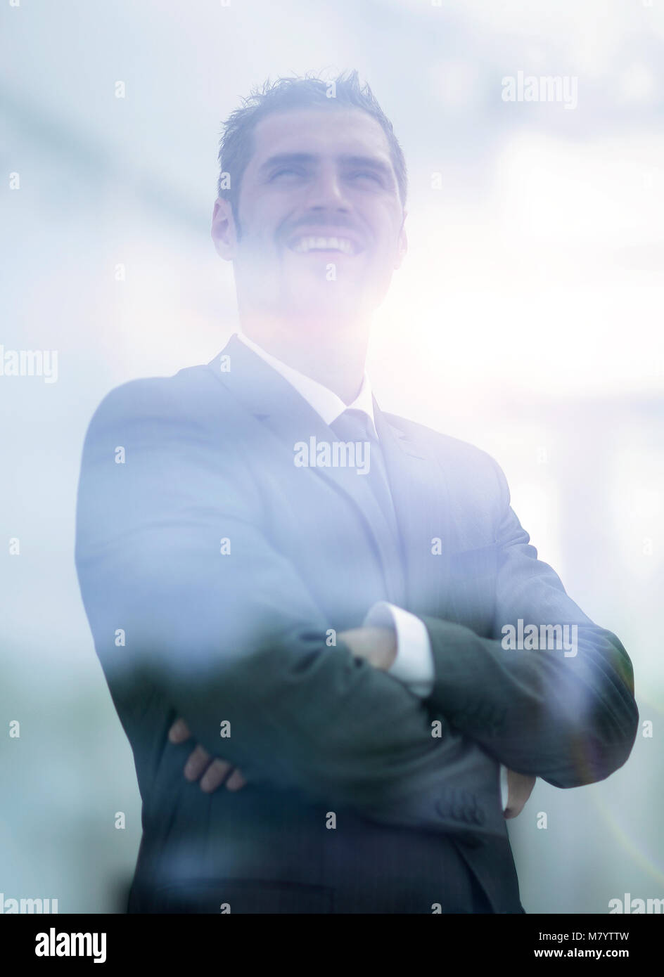 from behind the glass. modern businessman looks out the window of the ...