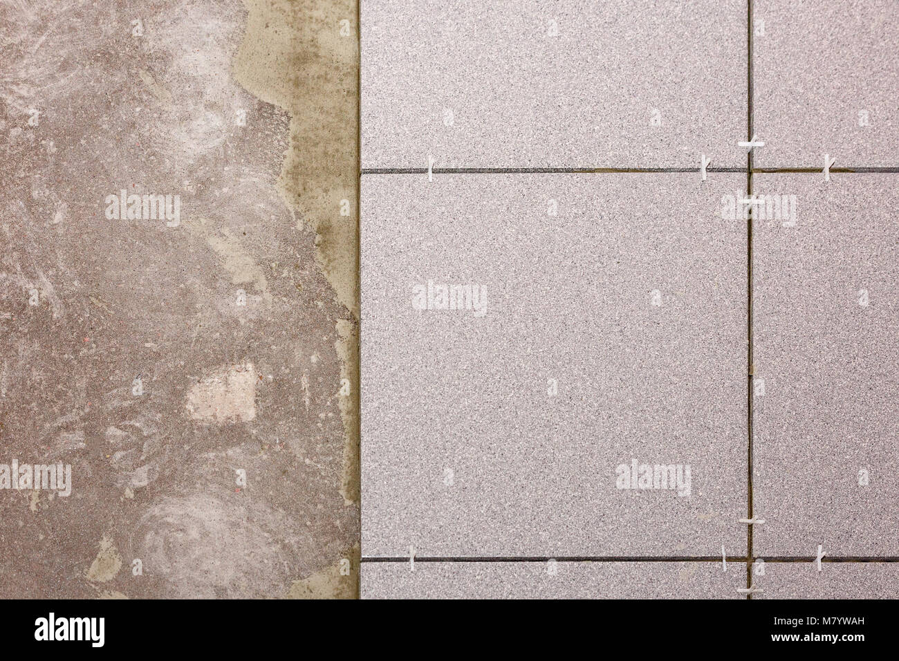 Fragment of the floor, in the process of laying ceramic tiles, close-up ...
