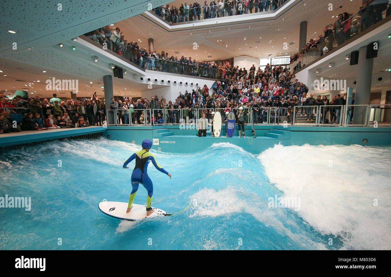 10 March 2018, Germany, Osnabrueck: A surfer standing on a surfboard in ...
