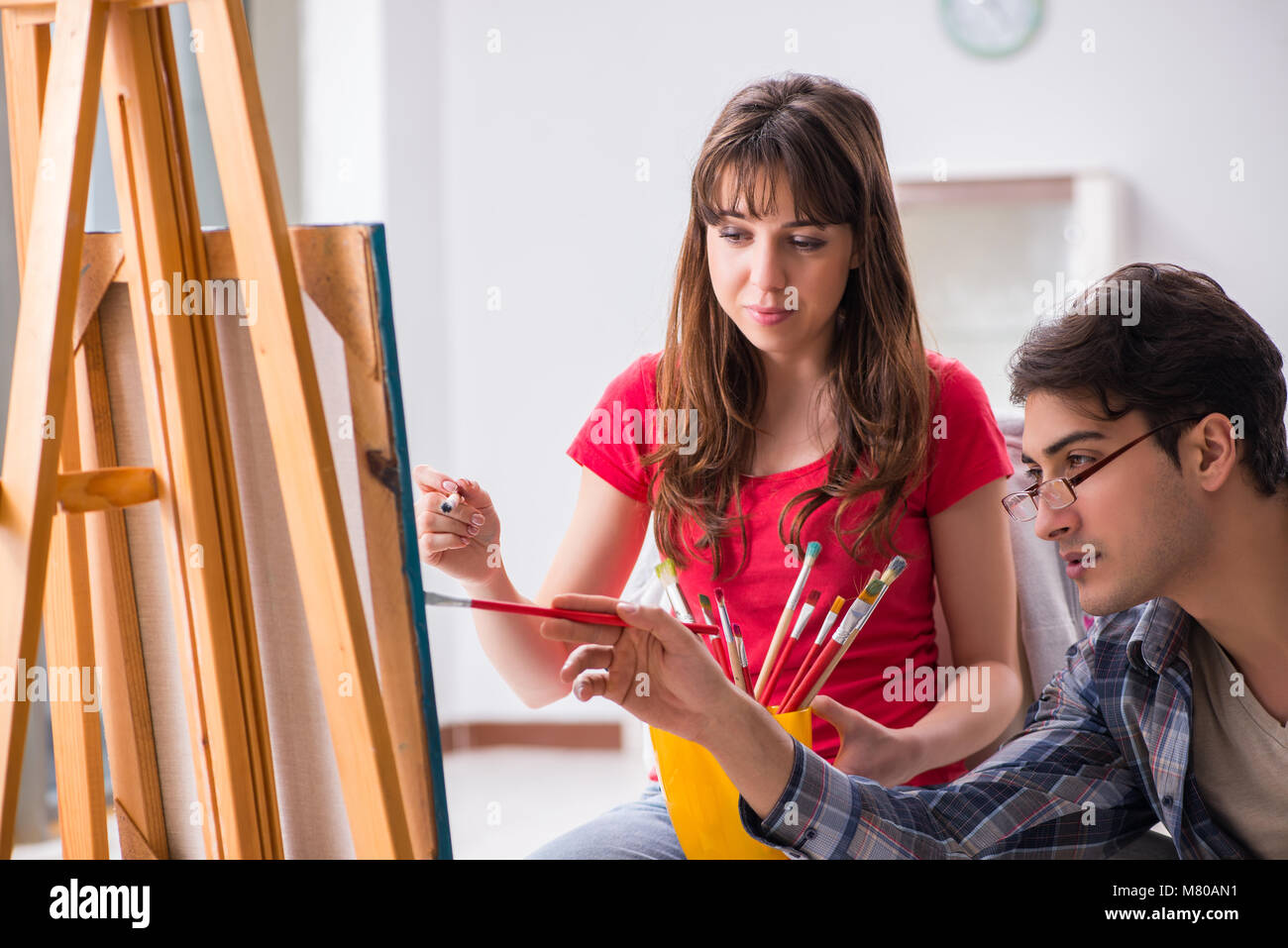 Artist coaching student in painting class in studio Stock Photo - Alamy