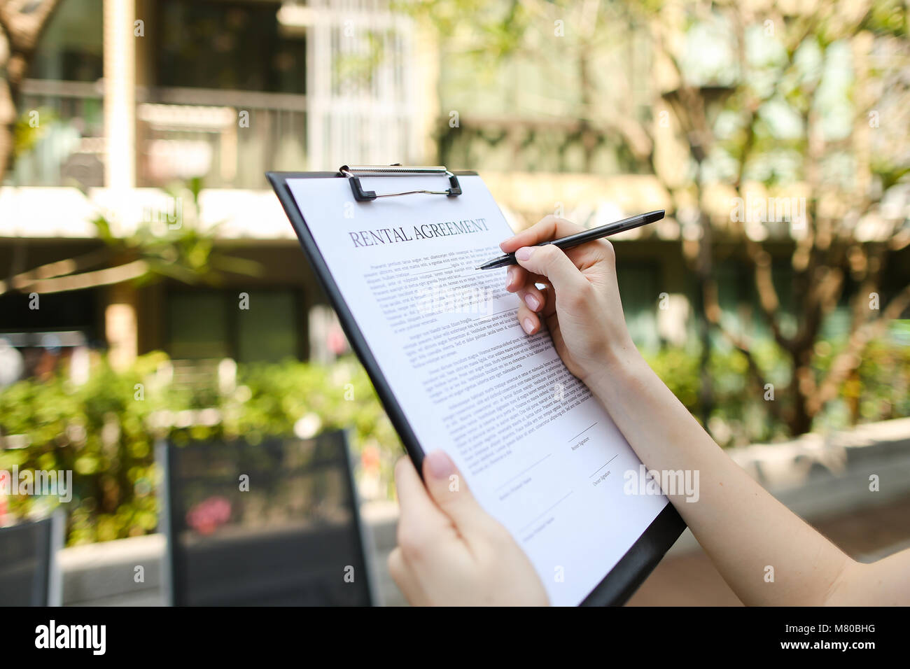 close up of woman hands signing rental agreement sunny day condo Stock ...