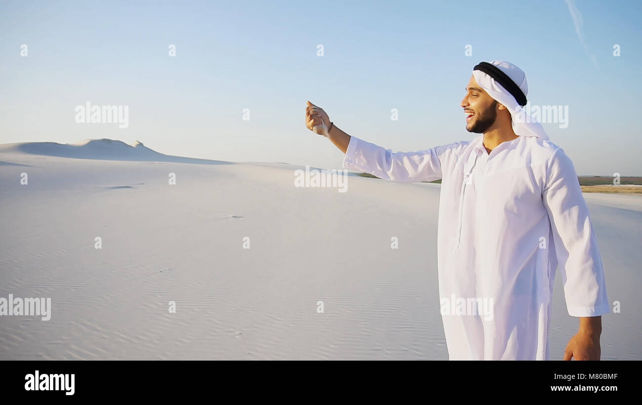 Joyful Arabian Sheikh man walks on top of desert with smile on f Stock ...