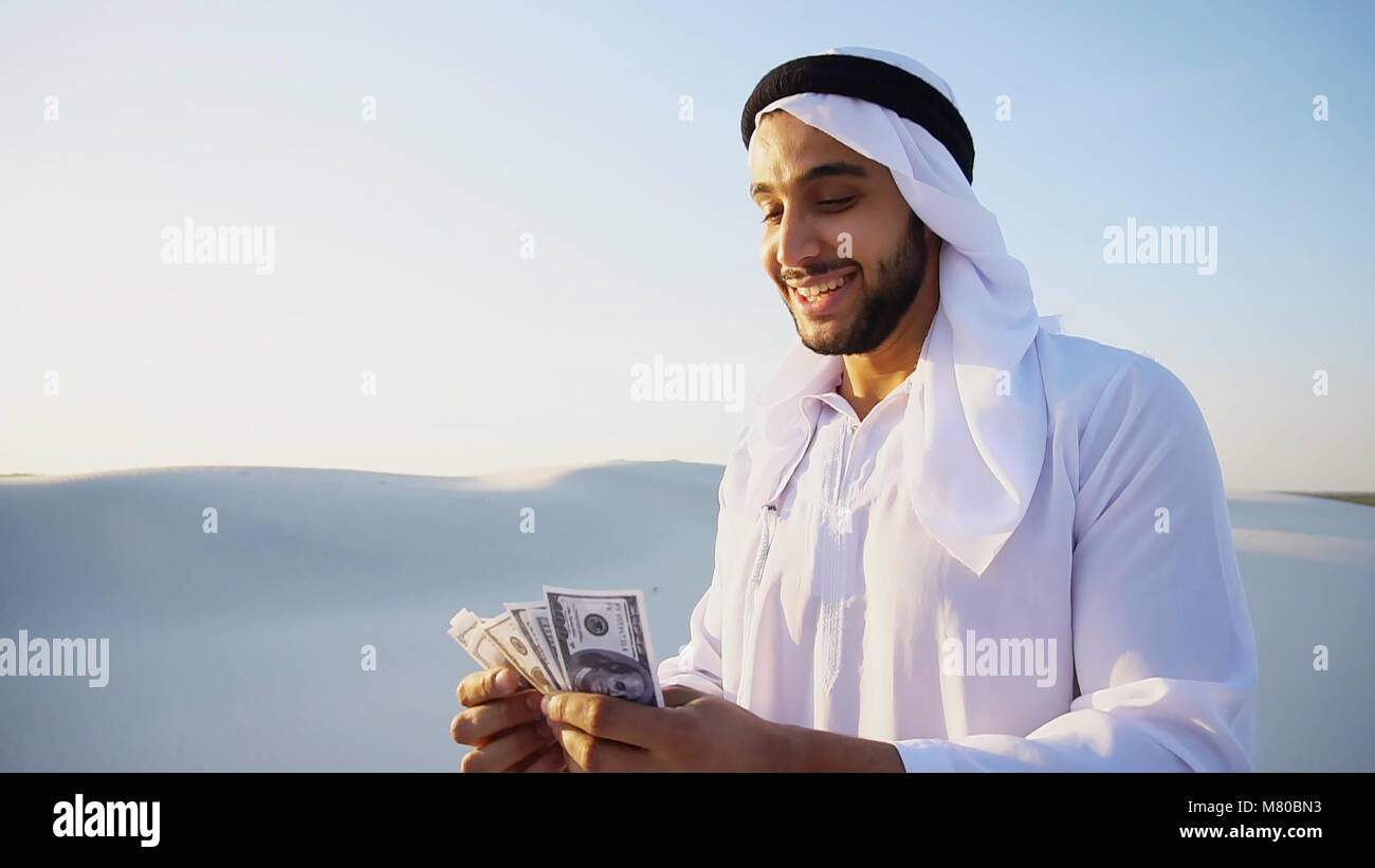 Successful Arab sheikh considers banknotes and happy, standing i Stock ...