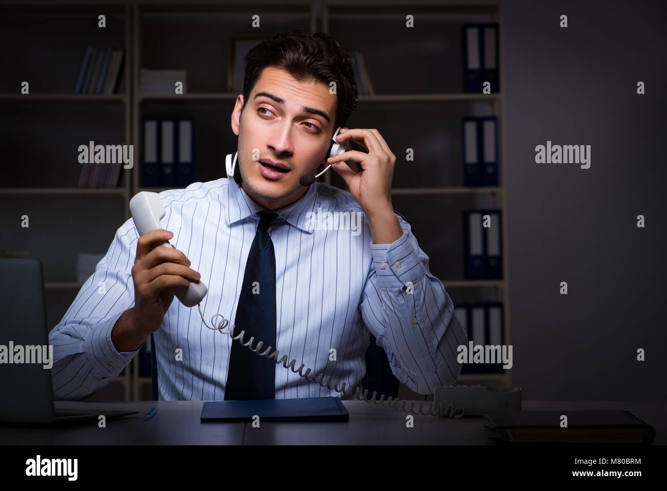Call center operator talking to customer during night shift Stock Photo ...