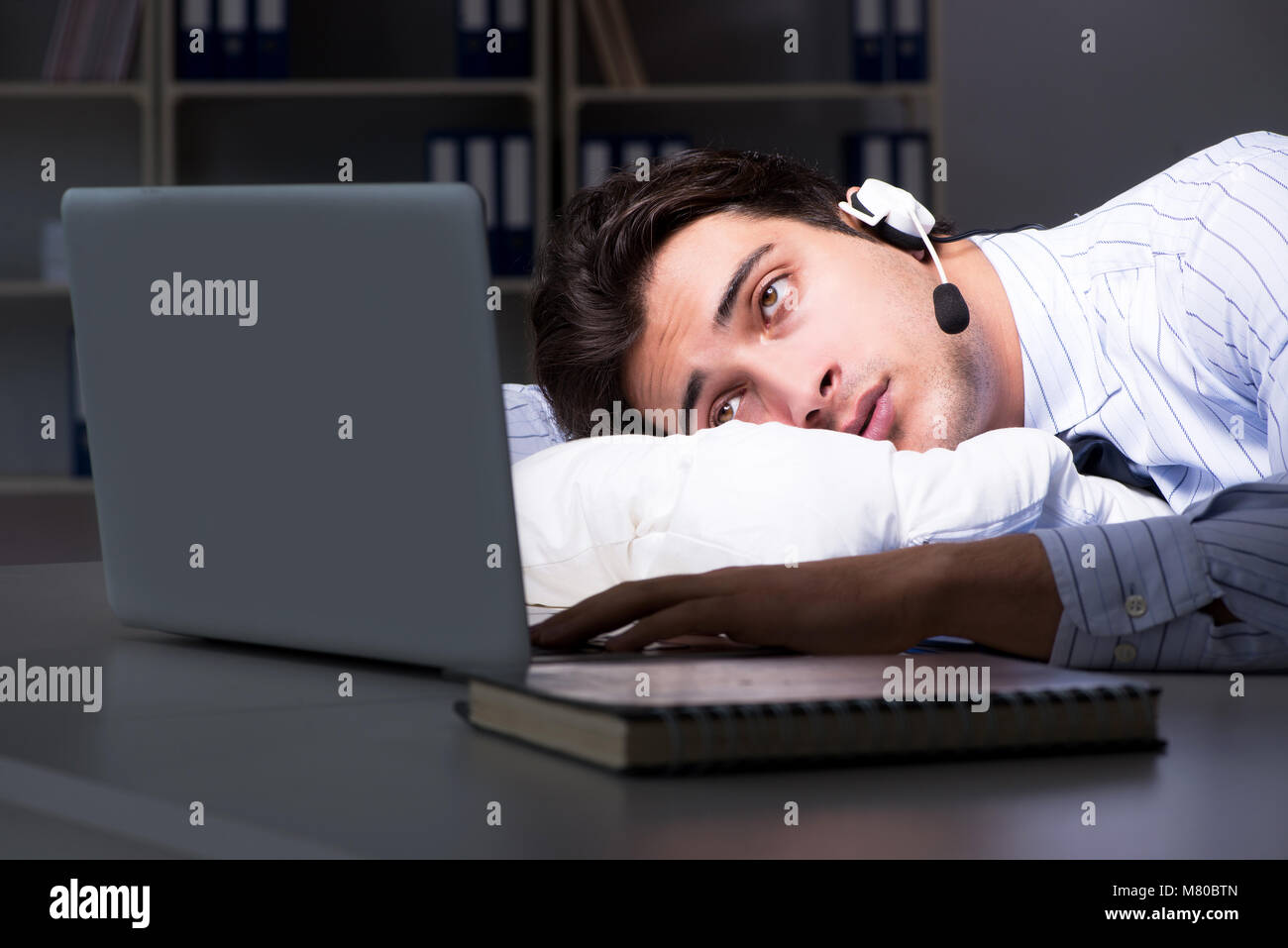 Tired and exhausted helpdesk operator during night shift Stock Photo ...