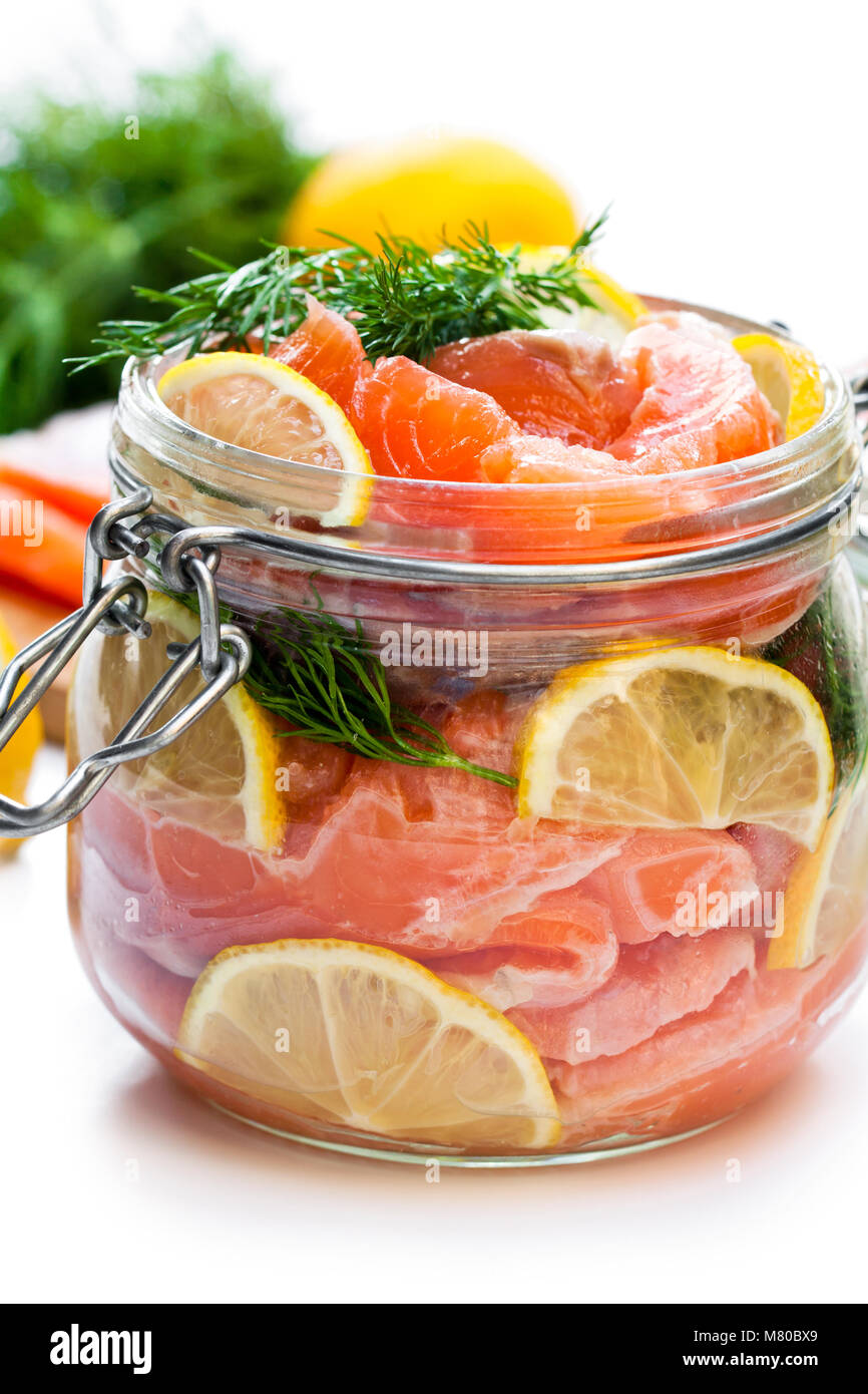 Salted salmon with lemon in glass jar isolated on white background ...
