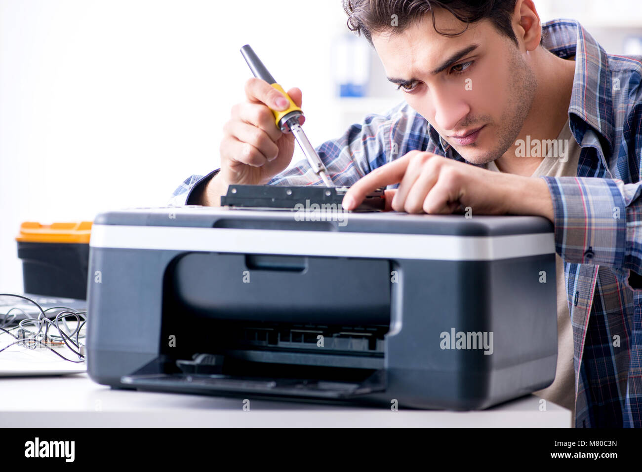 Hardware repairman repairing broken printer fax machine Stock Photo - Alamy