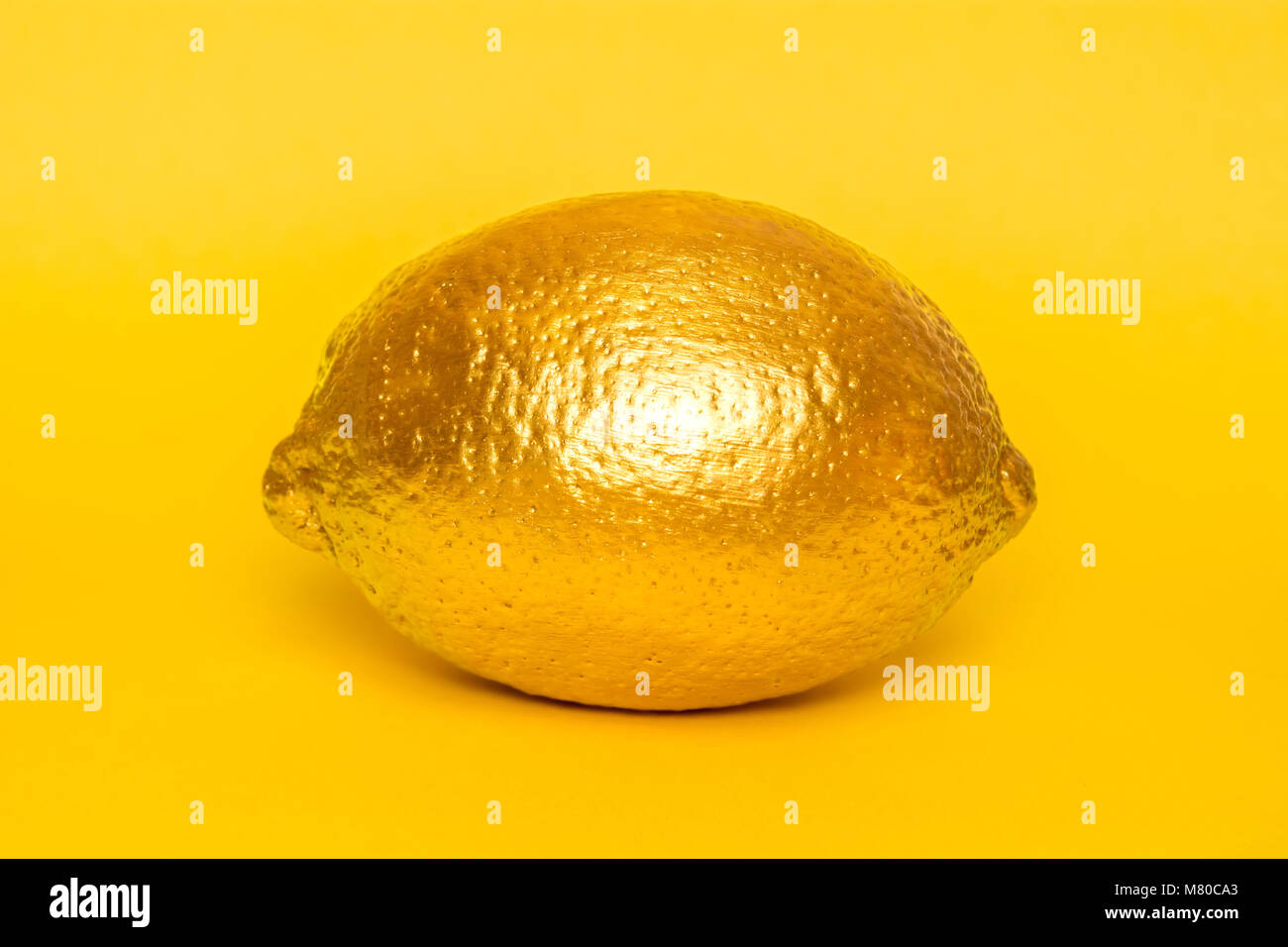 Gold lemon on yellow background. Creative concept with fruit Stock ...