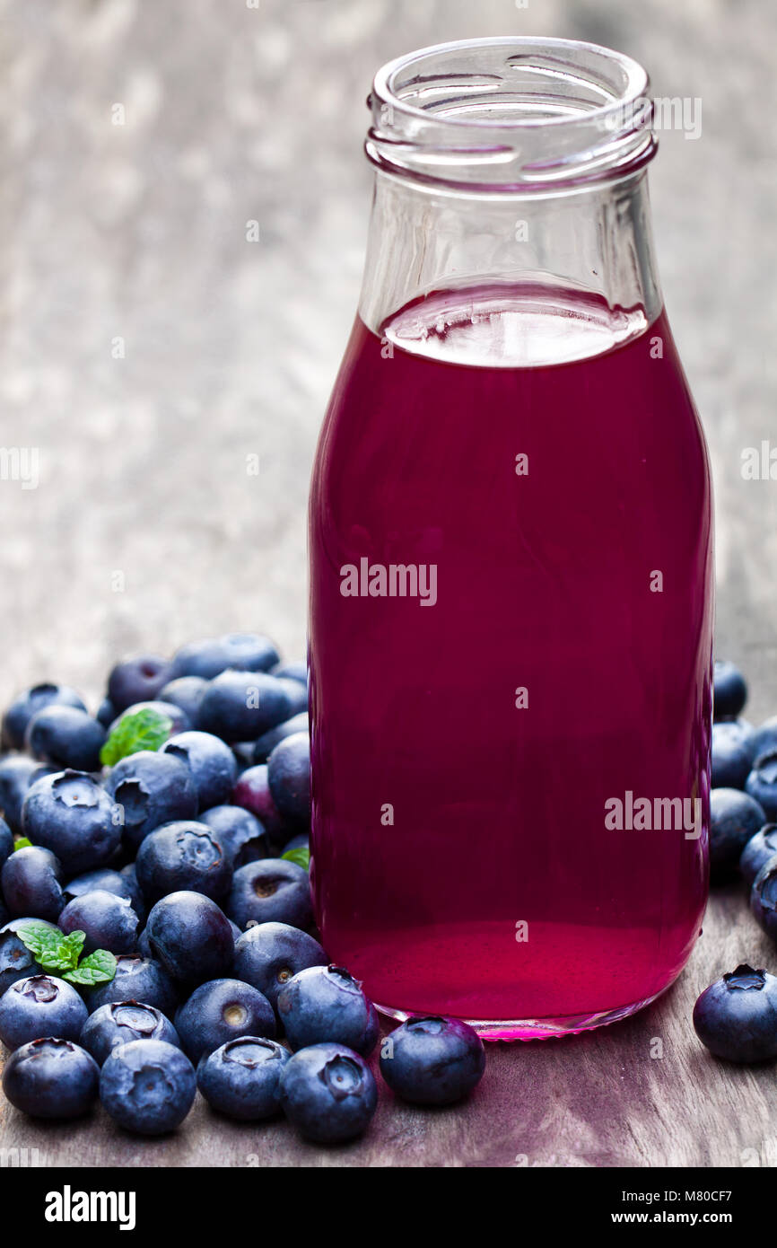Blueberry juice in glass bottle on wooden table Stock Photo - Alamy