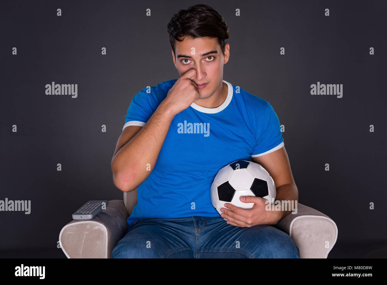 Man watching sports on gray background Stock Photo - Alamy