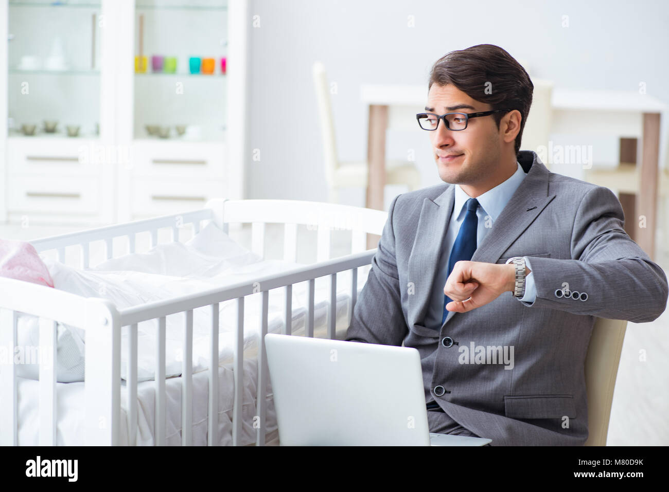 Young businessman trying to work from home caring after newborn baby ...