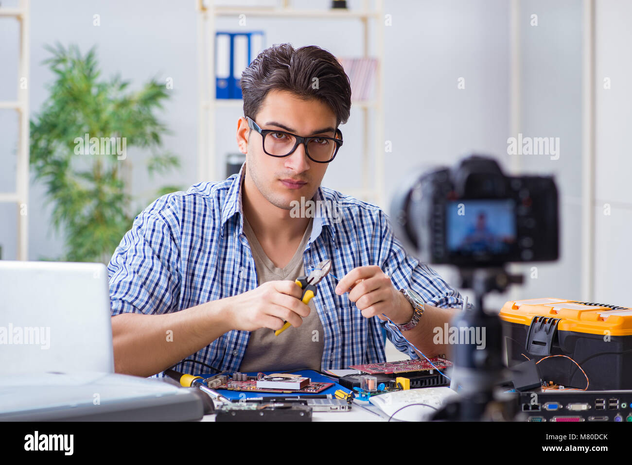 Vlogger recording computer repair on camera for vlog blog Stock Photo - Alamy