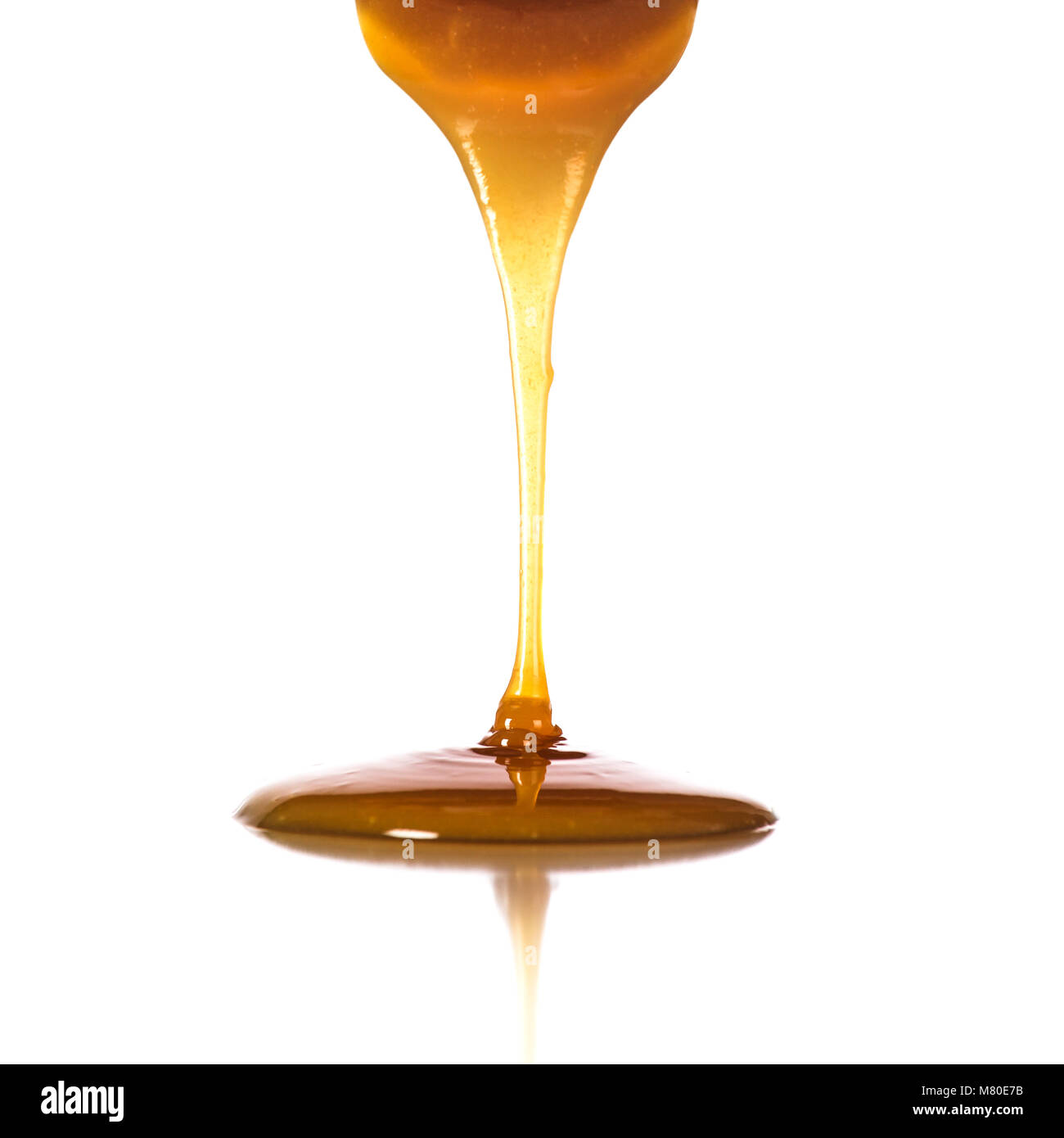 Pouring caramel sauce on white background Stock Photo - Alamy