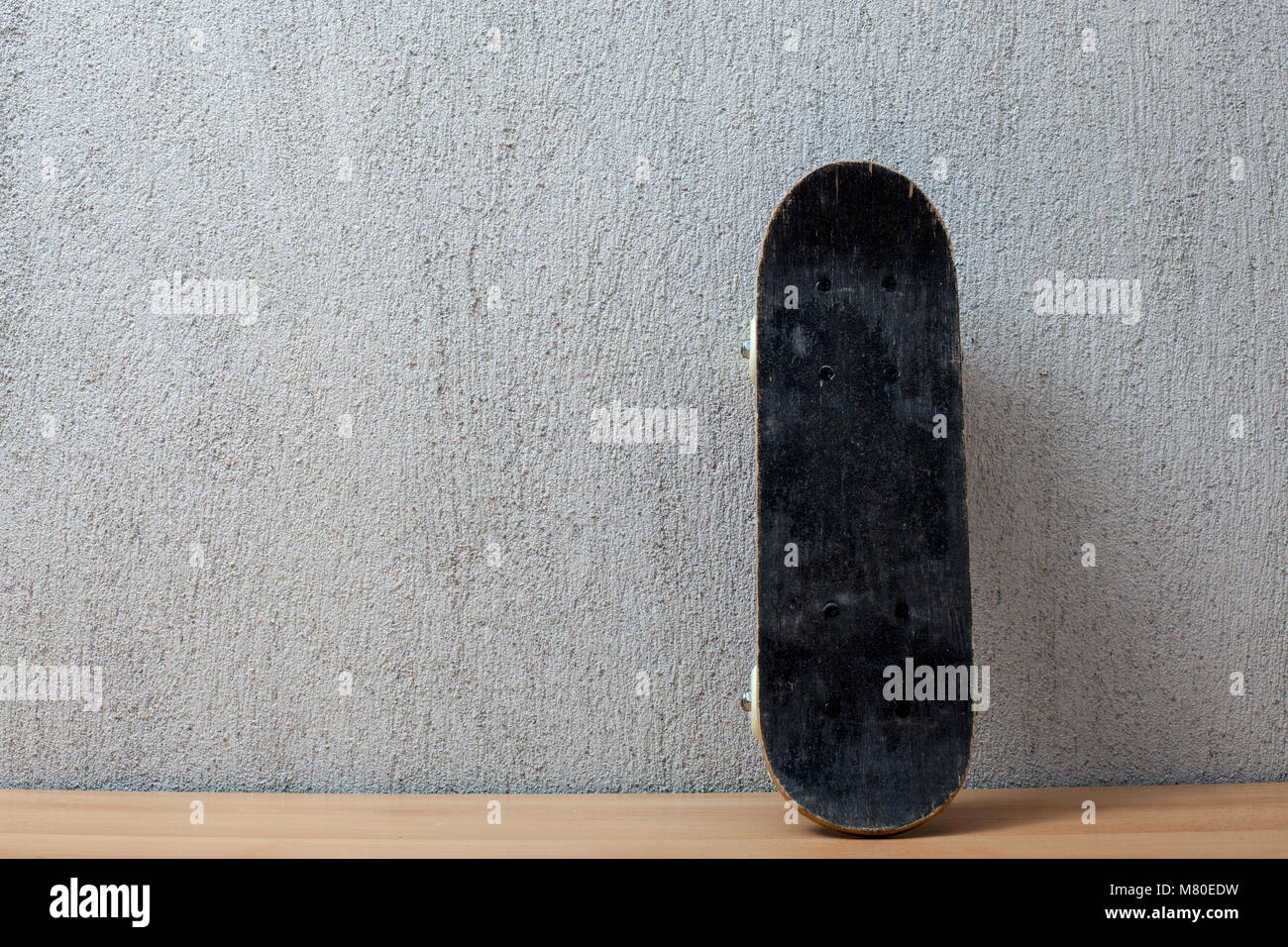 Skateboard standing on a wall Stock Photo - Alamy