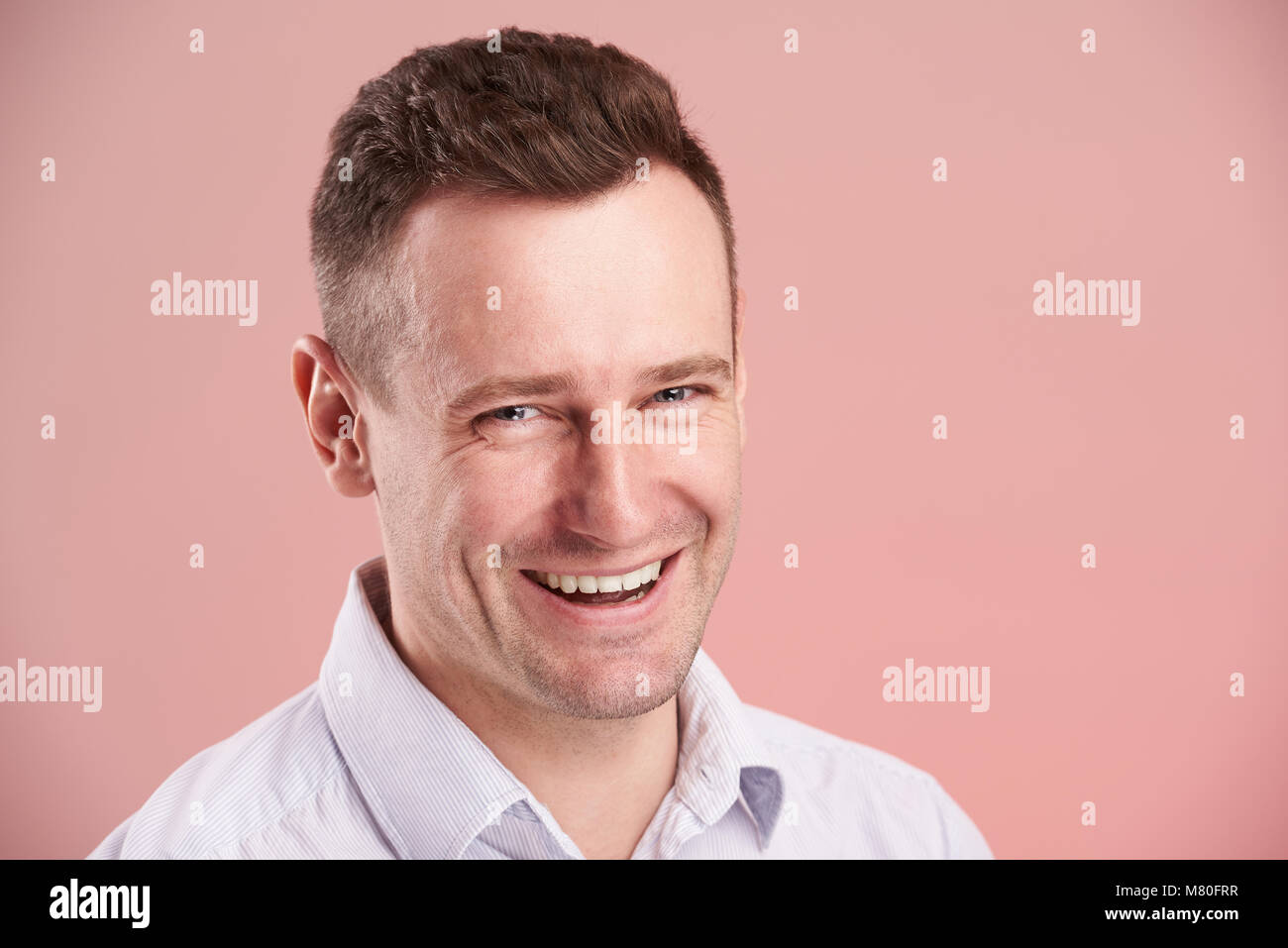 Happy laughing young man portrait isolated on pink background Stock ...