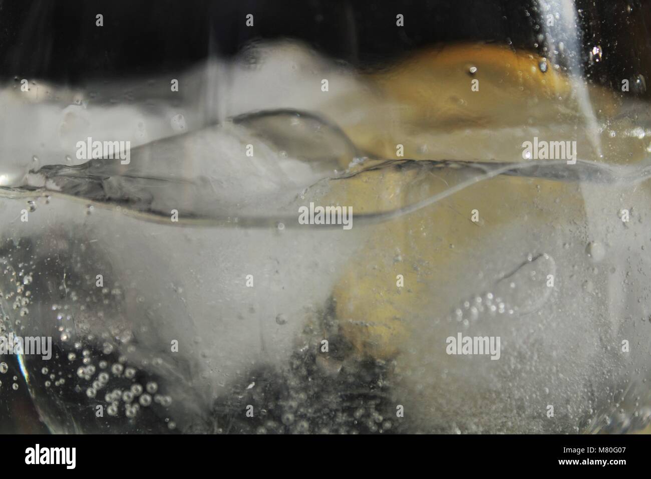 Gin and tonic on the rocks with lemon texture on a glass Stock Photo ...
