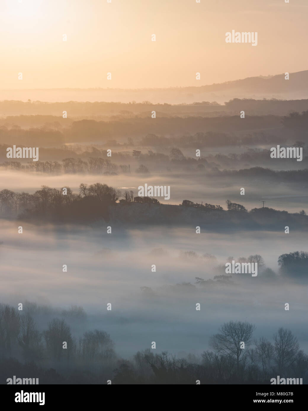 Beautiful foggy English countryside landscape at sunrise in Winter with ...