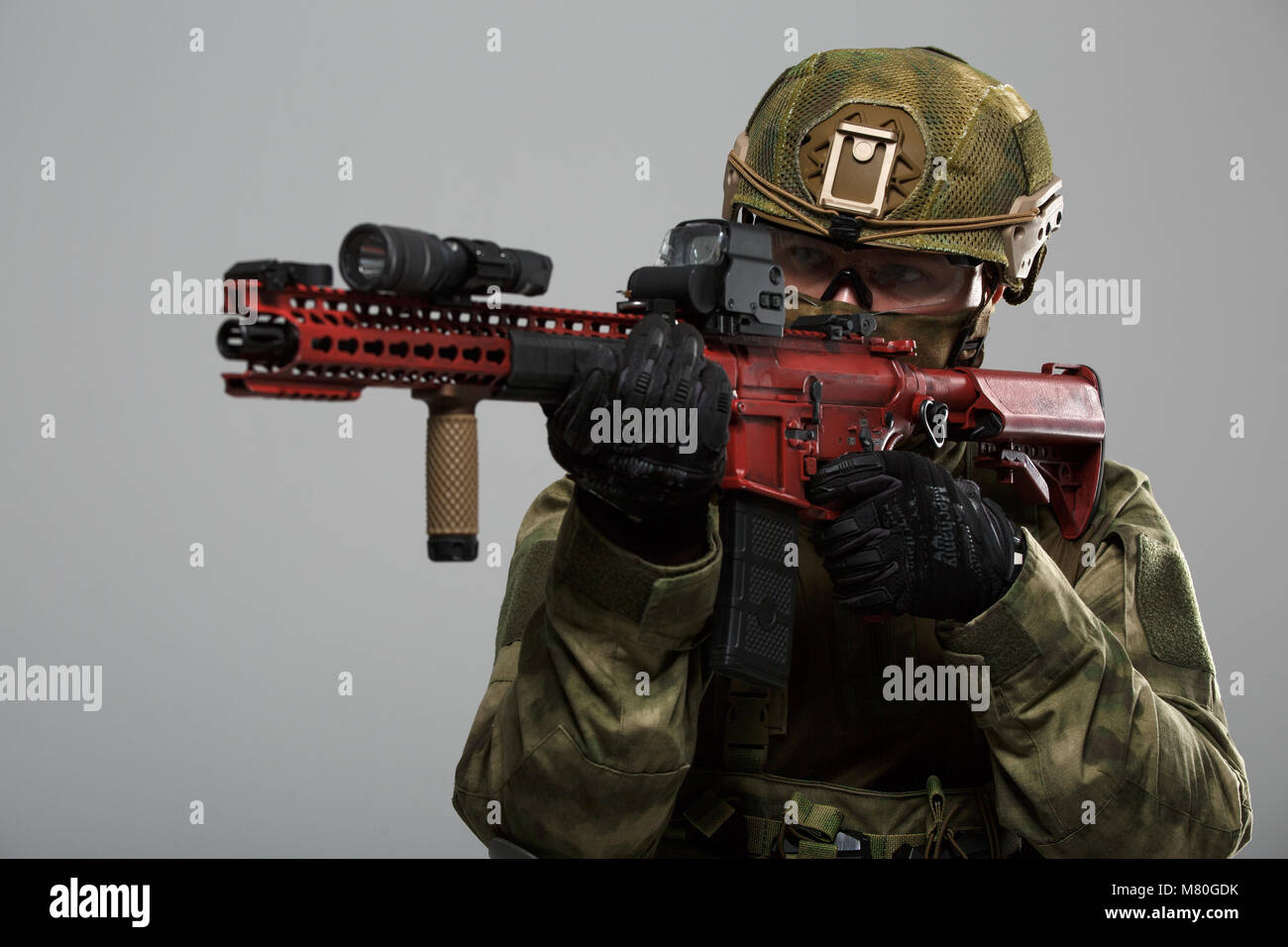Image of aiming military man in helmet with gun on empty gray ...
