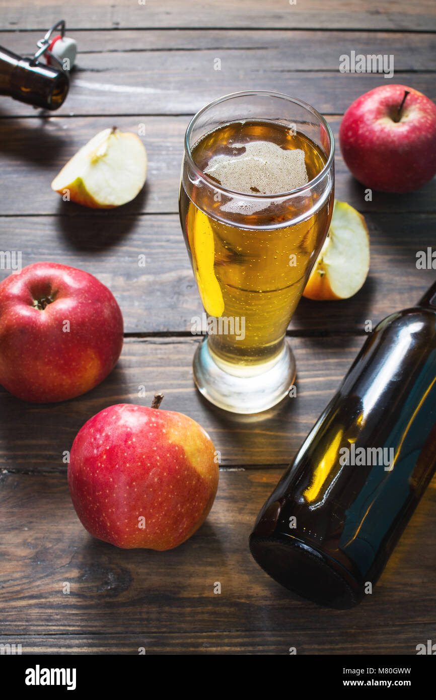 Glass of cider with apples and bottle on rustic wooden background Stock ...