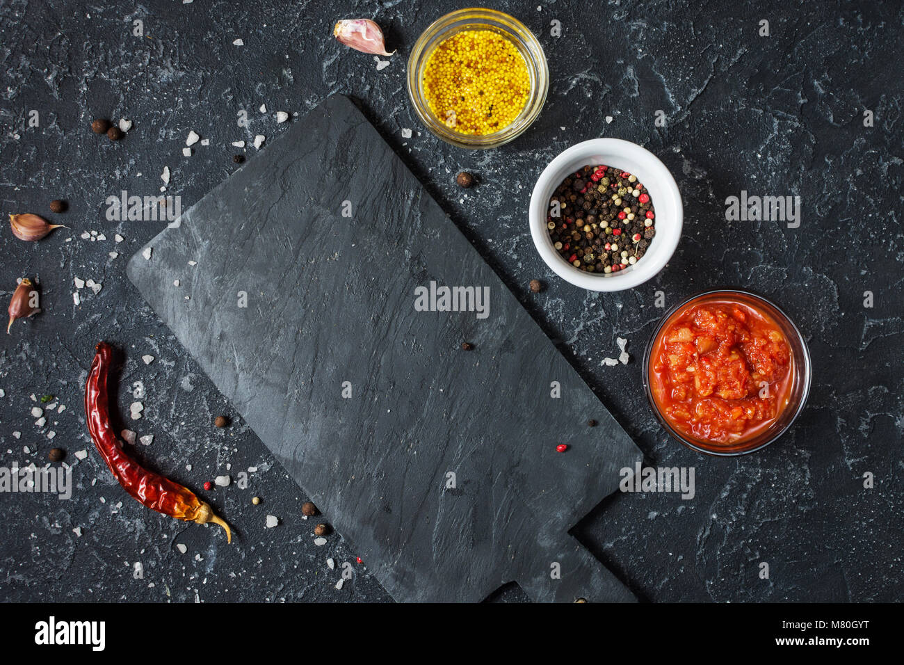 Black slate board, mustard, sauce and spices. Cooking or food ...