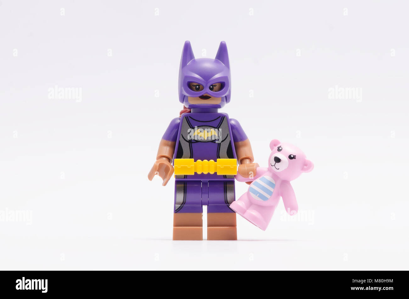 lego batgirl holding pink teddy bear. isolated on white background ...