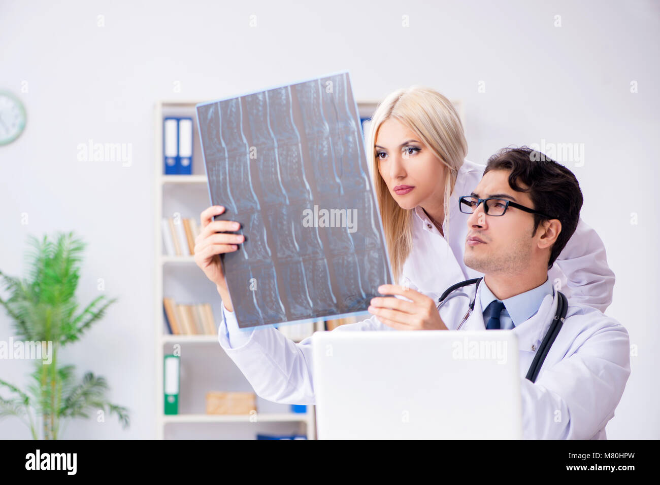 Two doctors examining x-ray images of patient for diagnosis Stock Photo ...