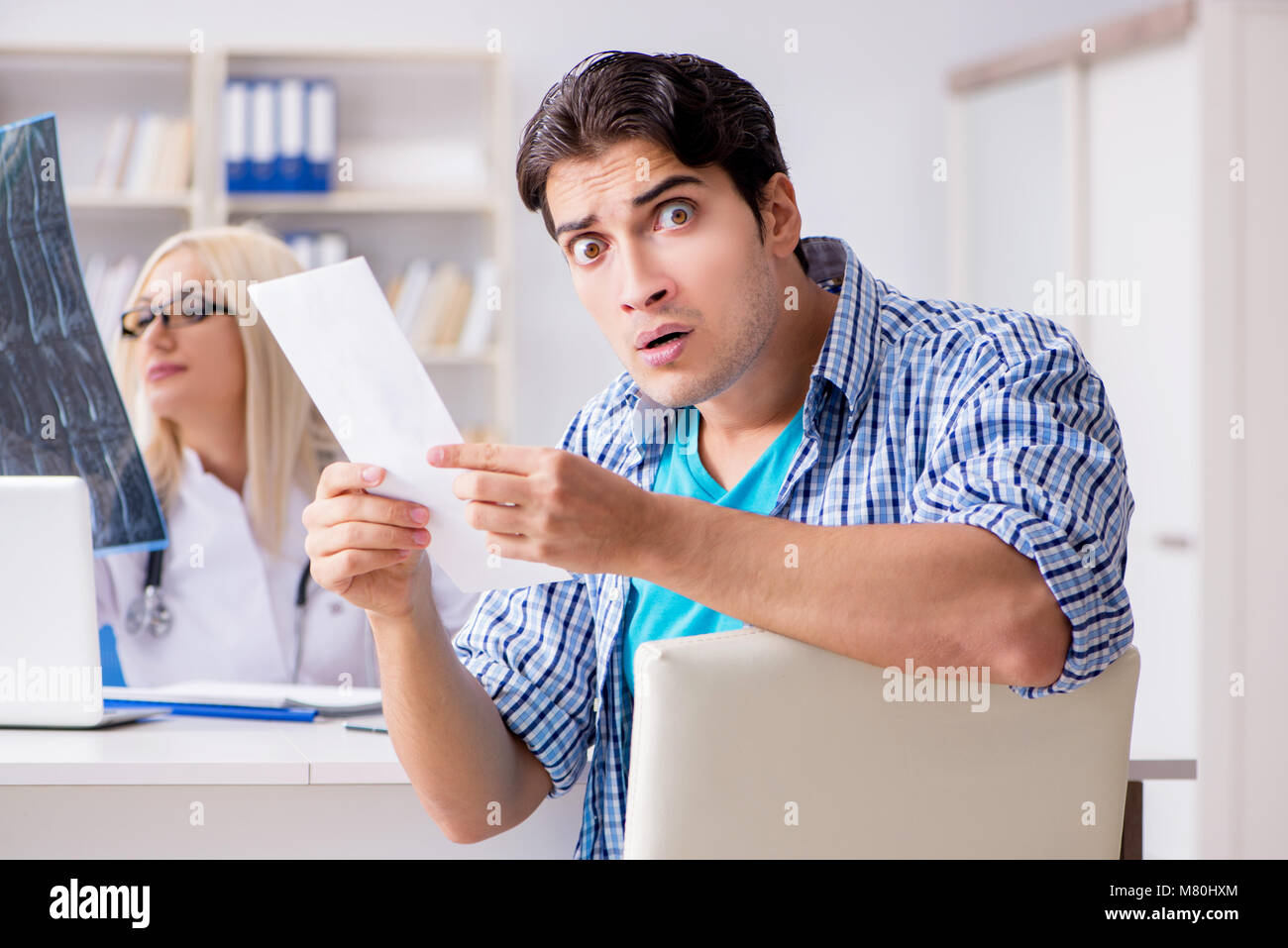 Male patient angry at expensive healthcare bill Stock Photo - Alamy