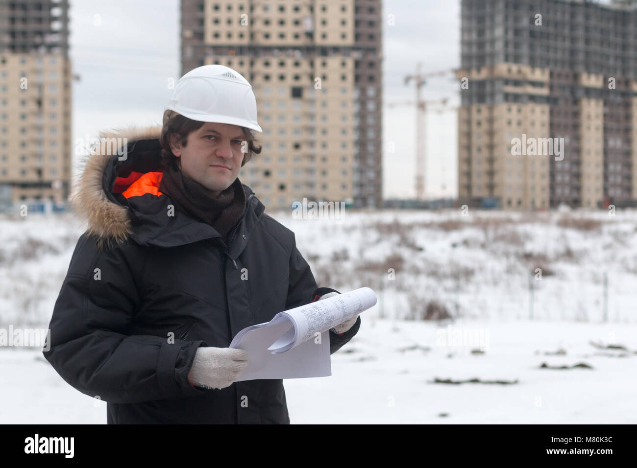 Worker or engineer holding drawing in hands and reading it on ...