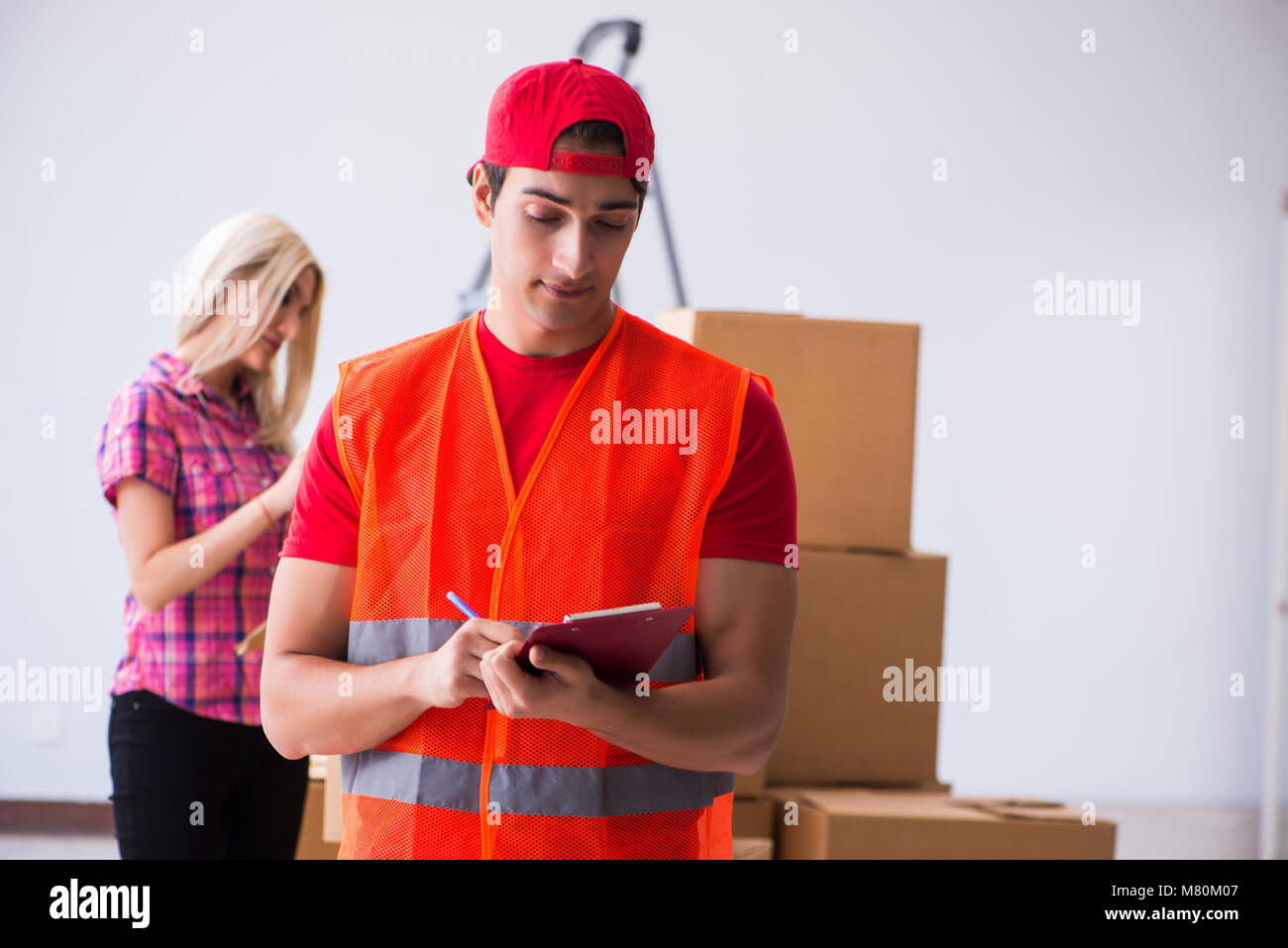 Young delivery assistant delivering to home Stock Photo - Alamy