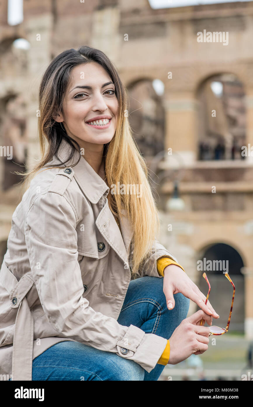 Young pretty tourist woman smiling and posing at colosseum monument in ...