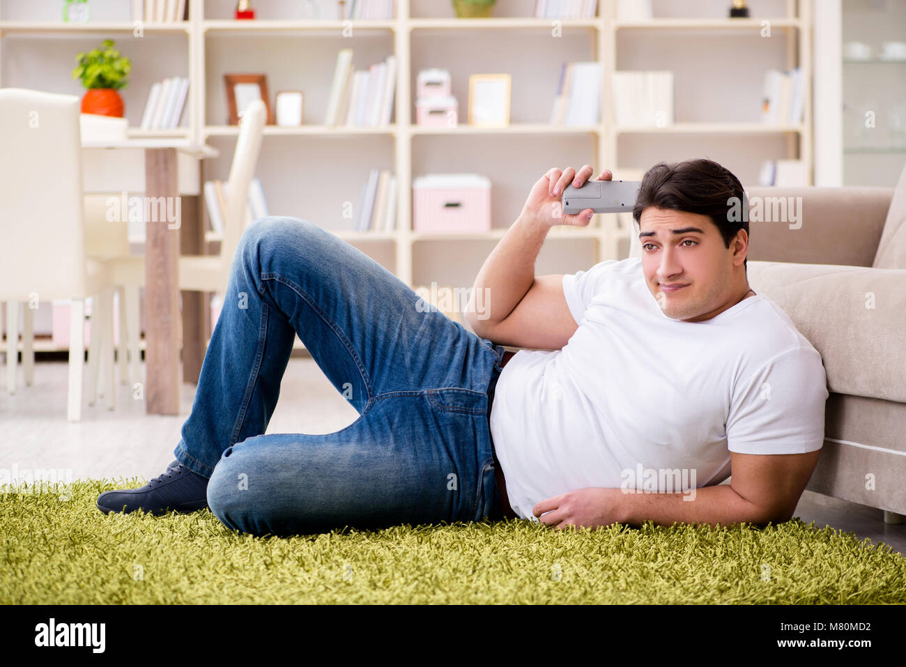 Man watching tv at home on floor Stock Photo - Alamy