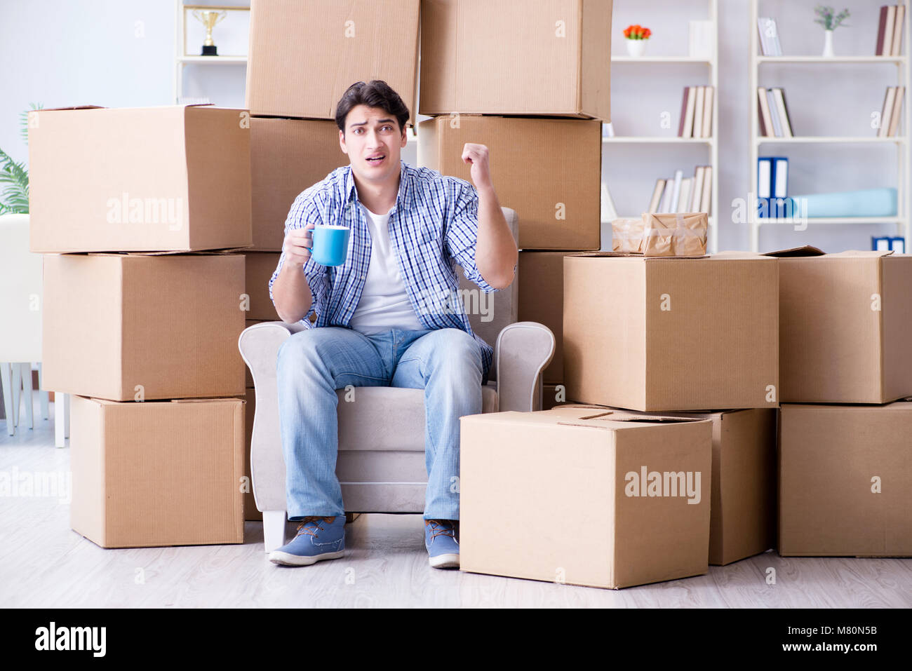 Young man moving in to new house with boxes Stock Photo - Alamy