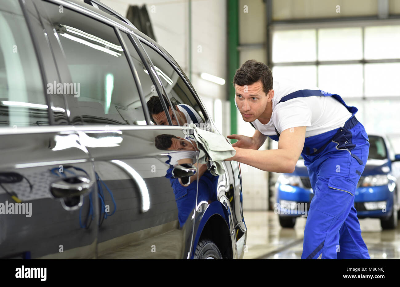 Car wash - employees of a car dealership clean a vehicle professionally ...