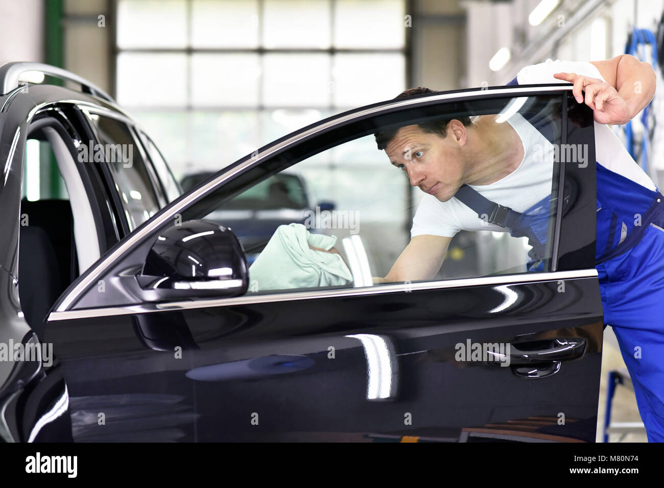 Car wash - employees of a car dealership clean a vehicle professionally ...