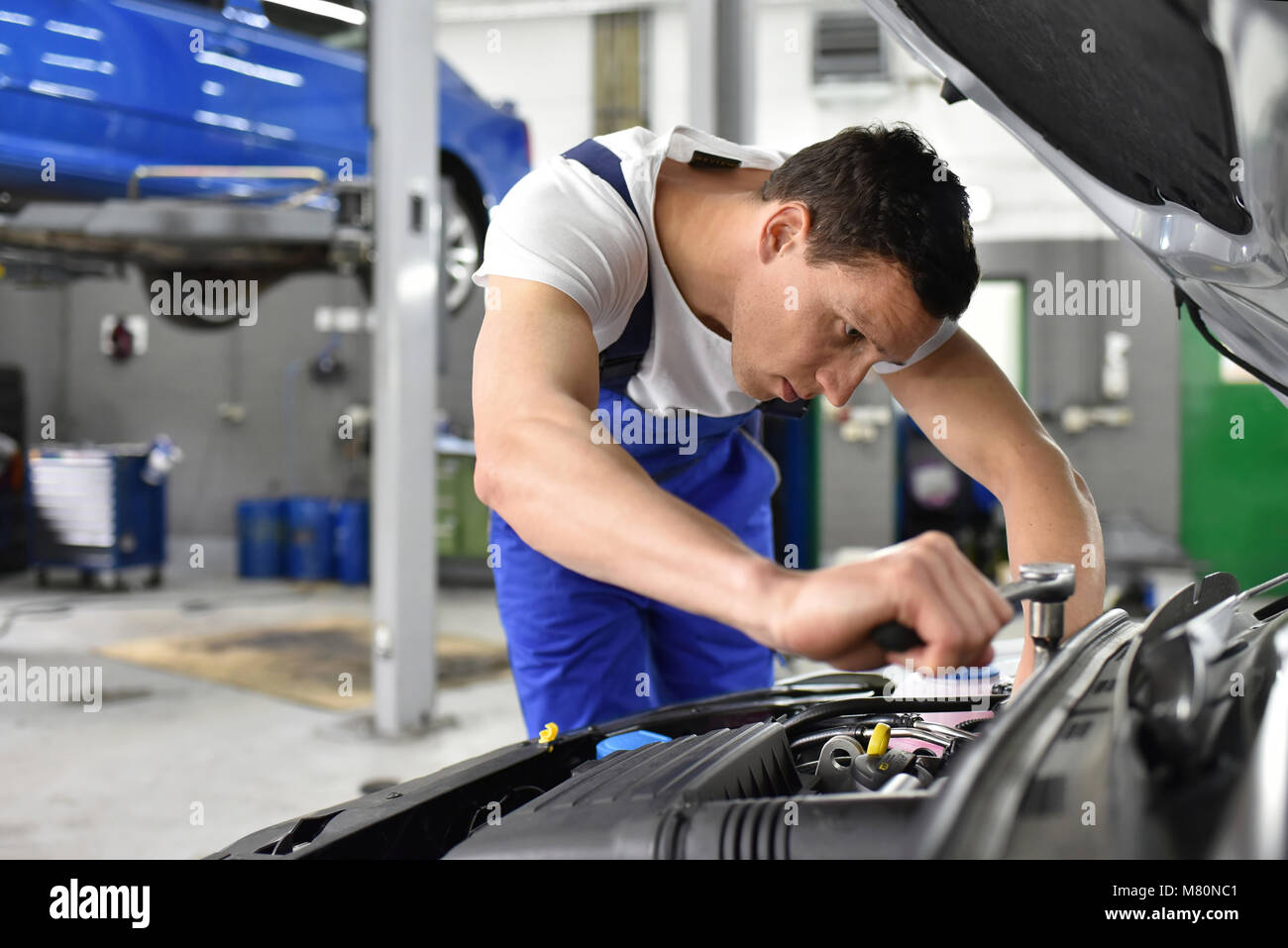 car mechanic in a workshop - engine repair and diagnosis on a vehicle ...