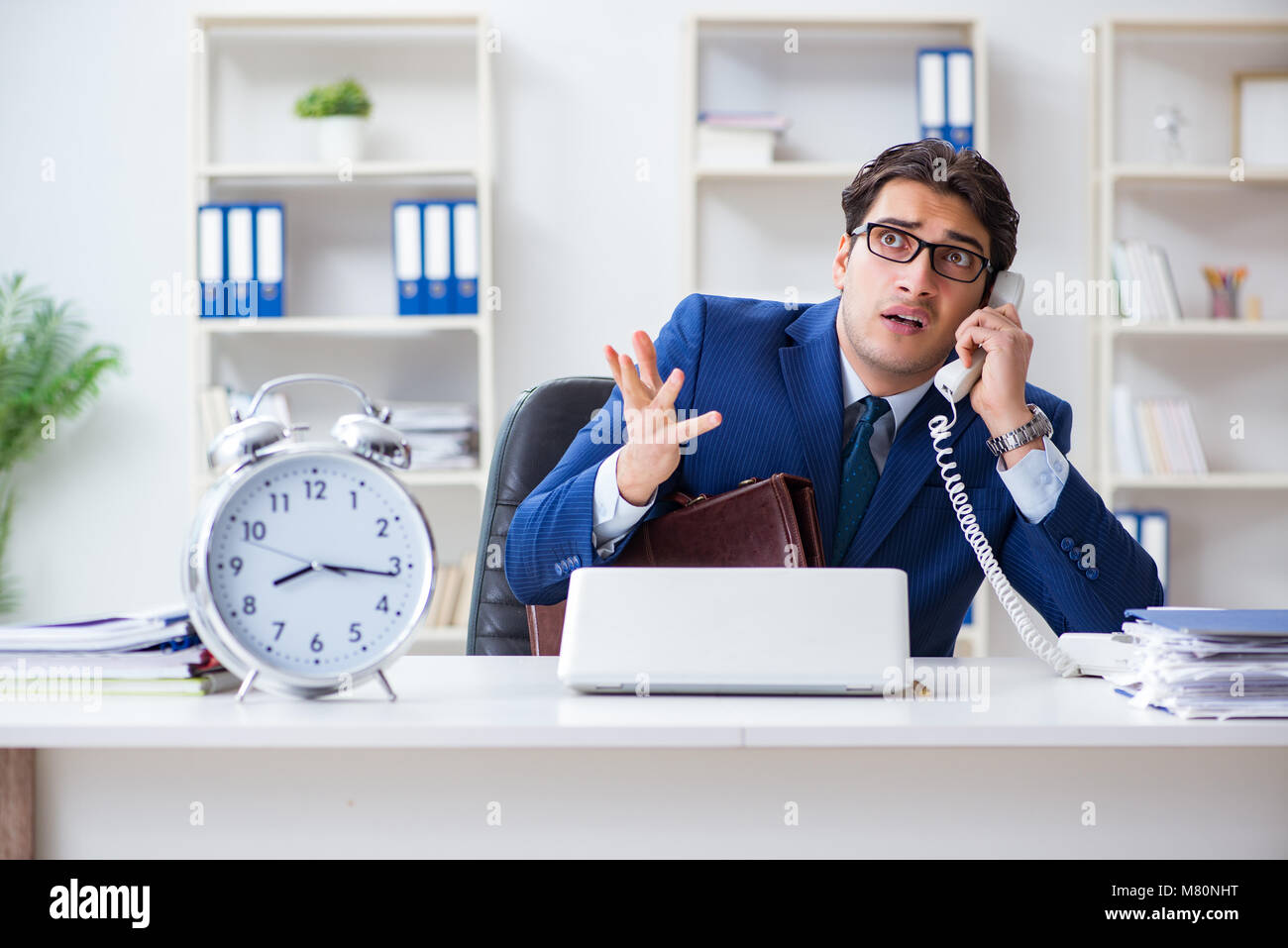 Businessman in bad time management concept Stock Photo - Alamy