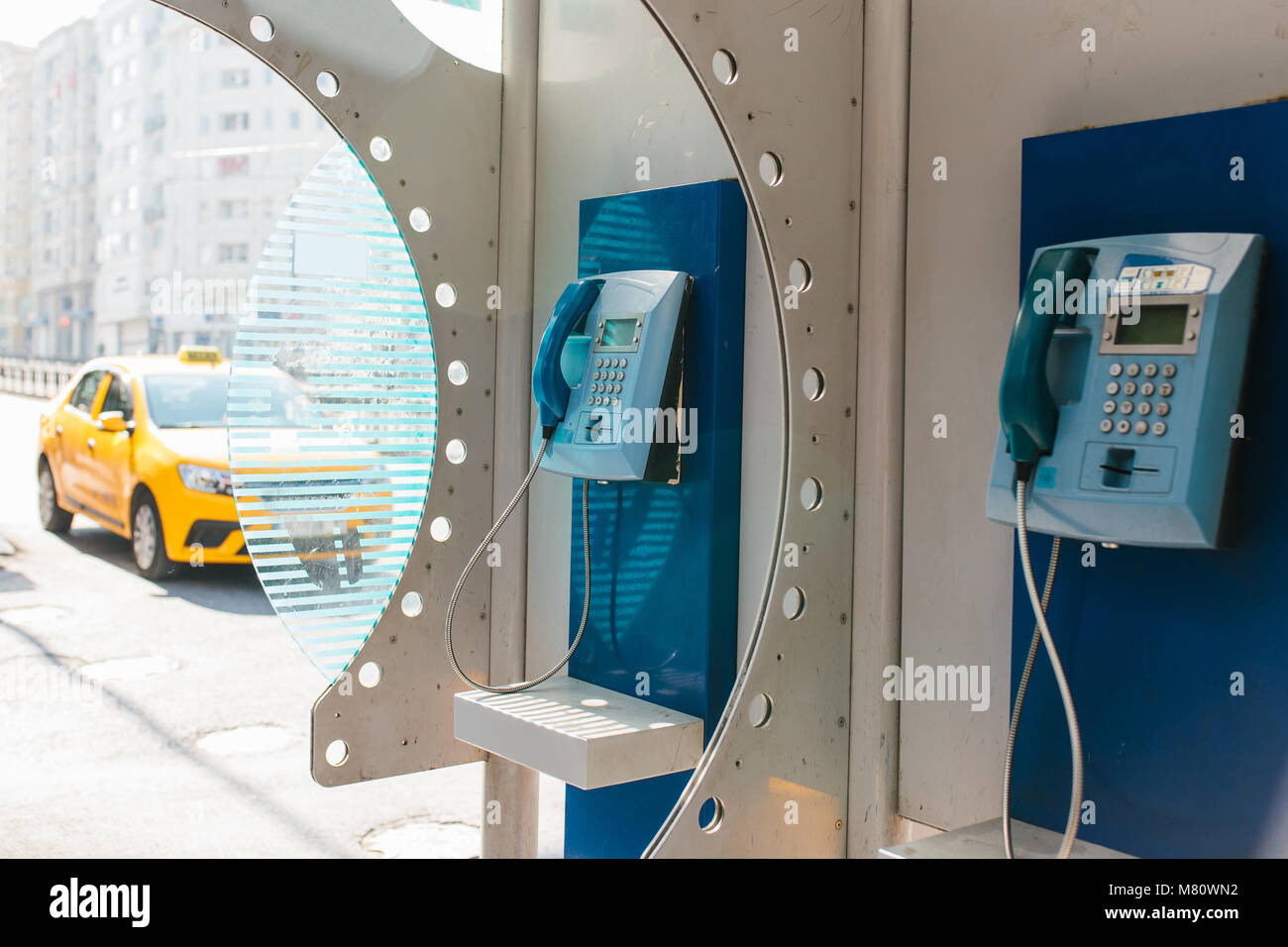 Street payphone with yellow taxi in the background. Travel concept ...