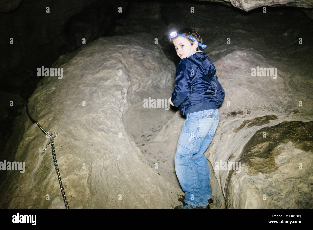 children explore underground caves, with electric torches exploring the ...