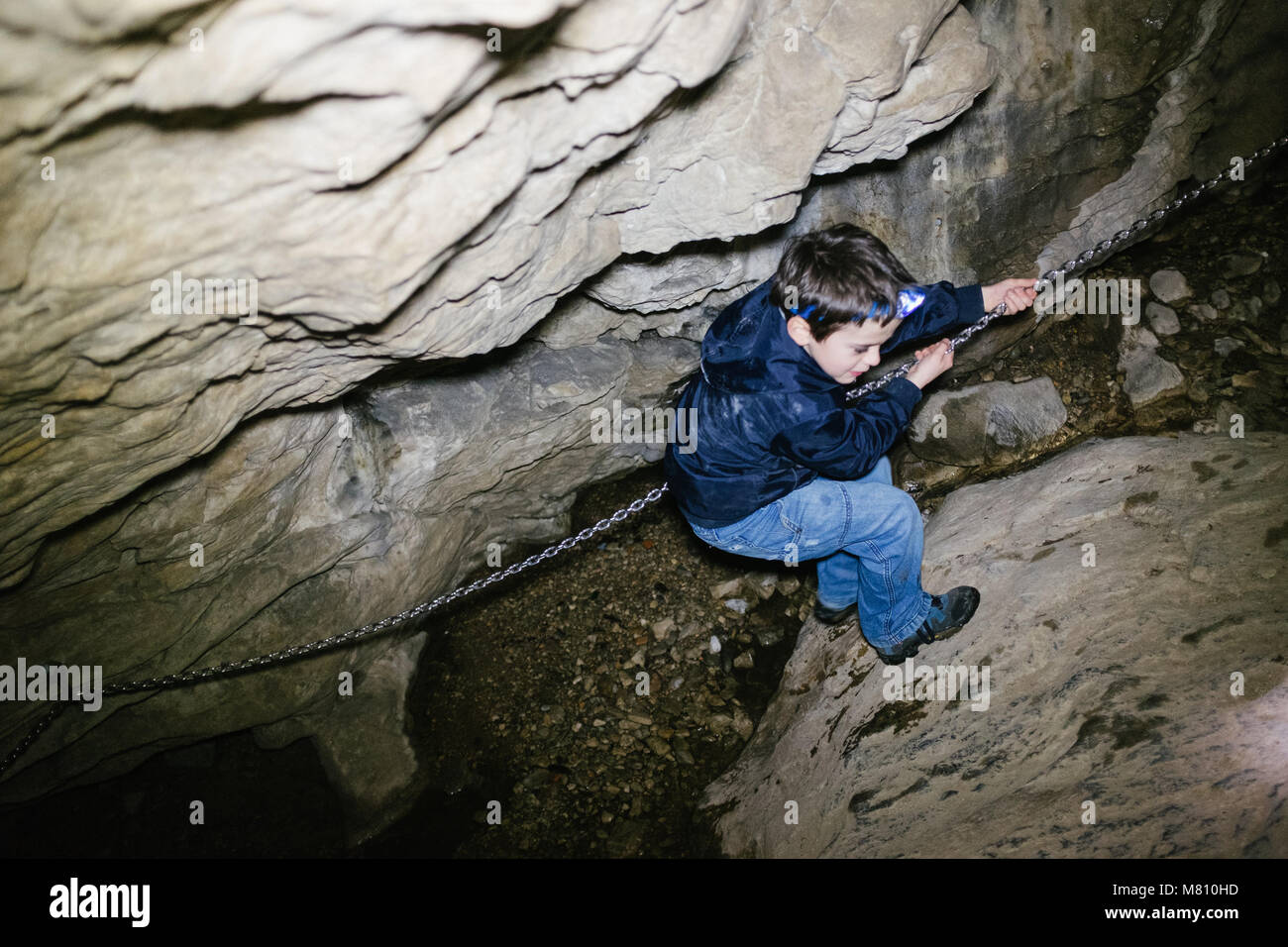 children explore underground caves, with electric torches exploring the ...