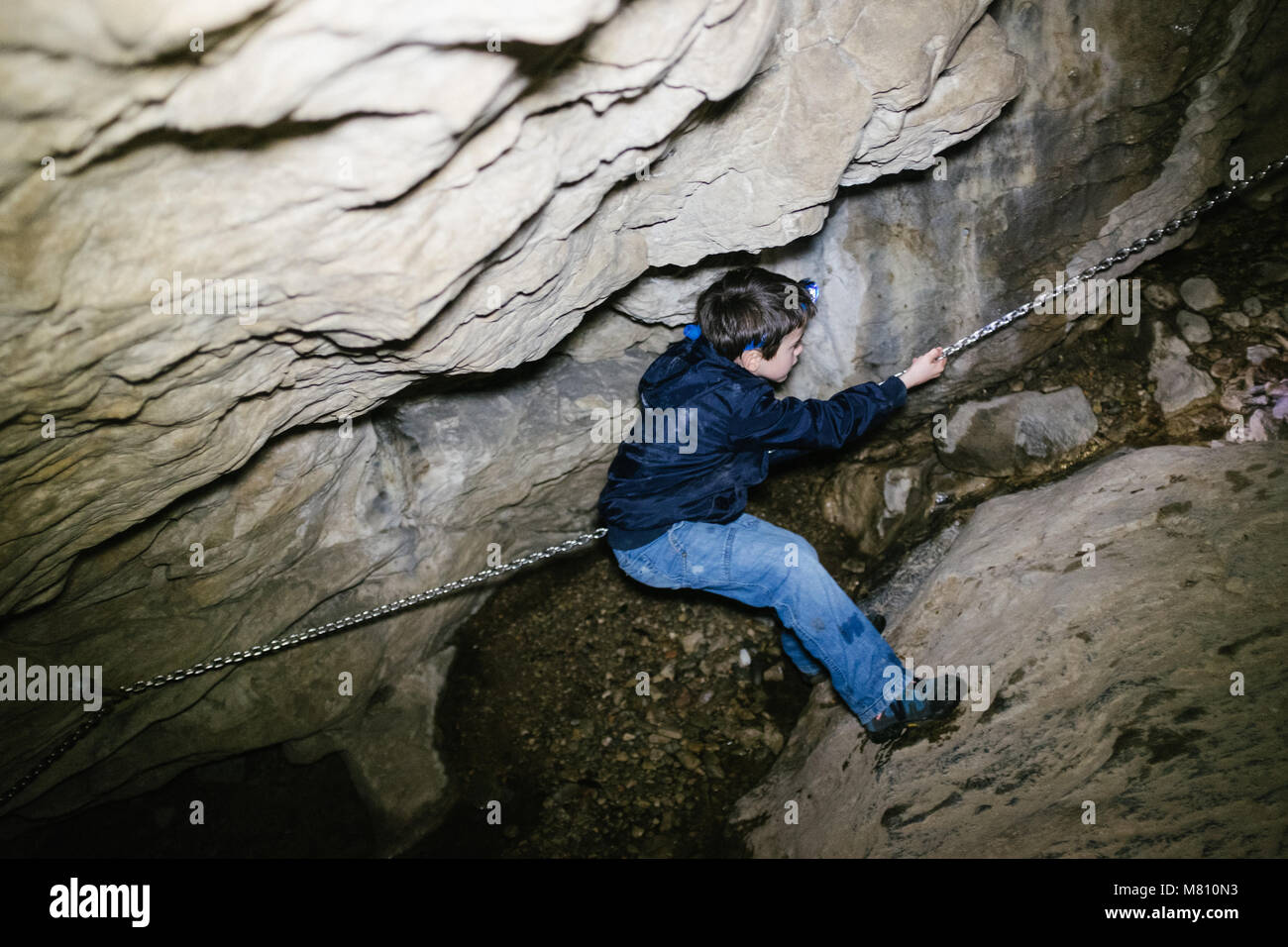 children explore underground caves, with electric torches exploring the ...