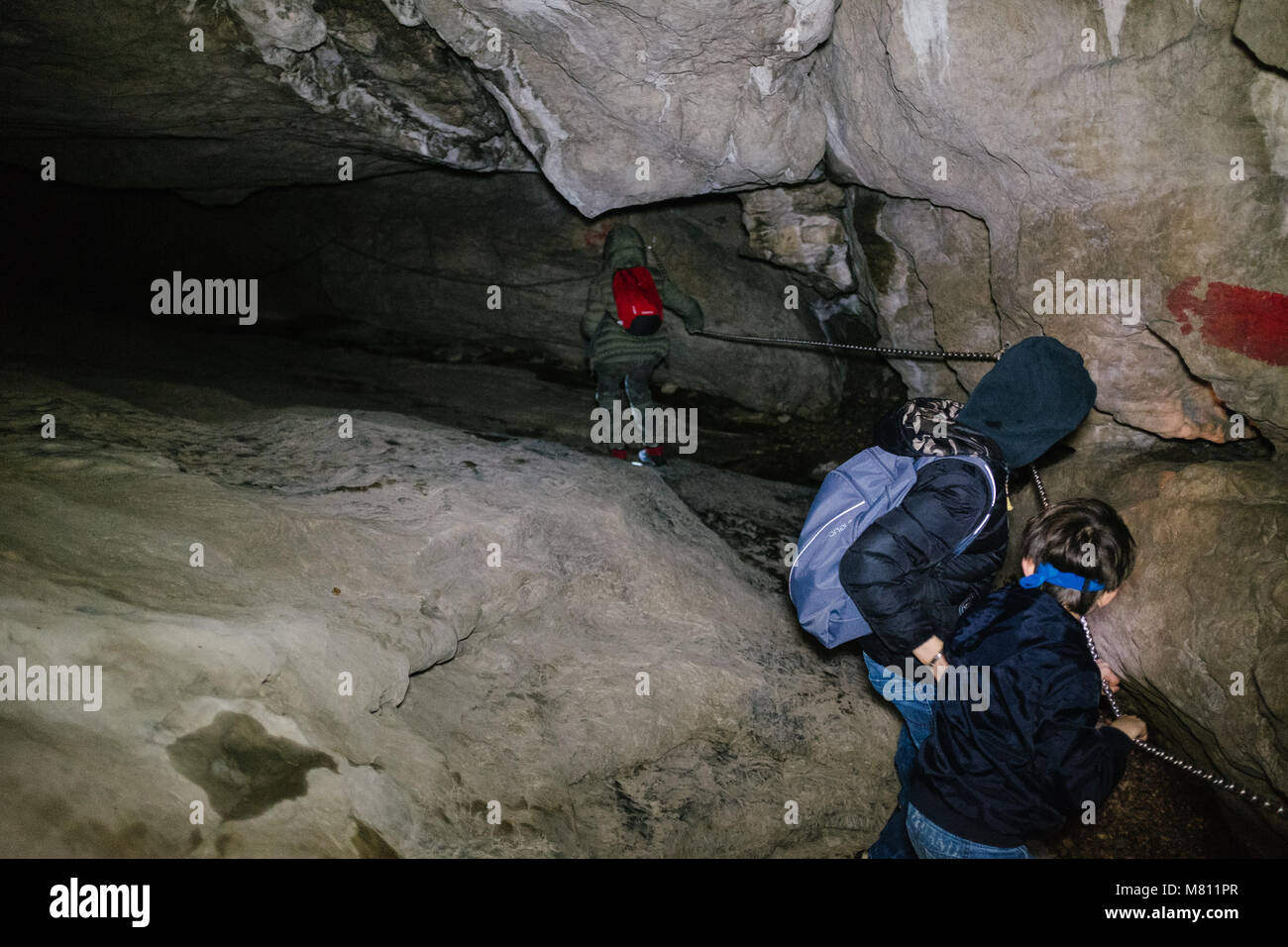 children explore underground caves, with electric torches exploring the ...