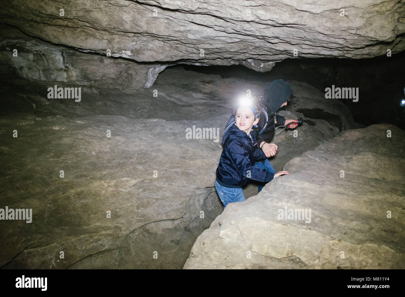 children explore underground caves, with electric torches exploring the ...