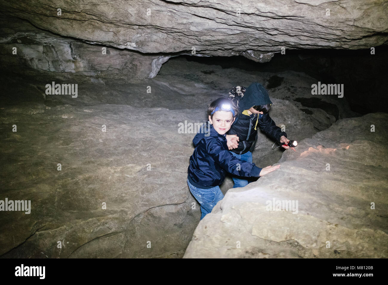 children explore underground caves, with electric torches exploring the ...
