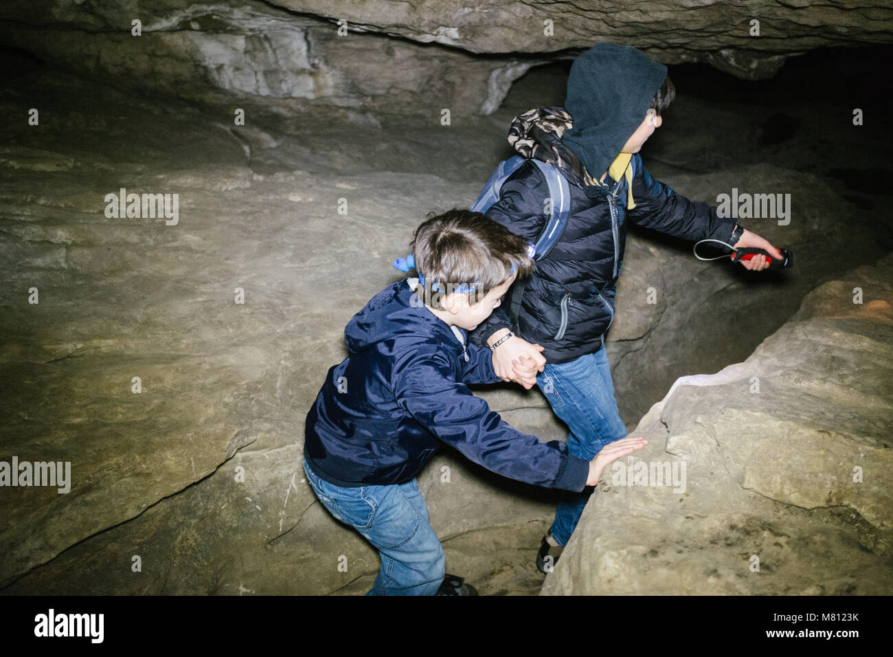 children explore underground caves, with electric torches exploring the ...