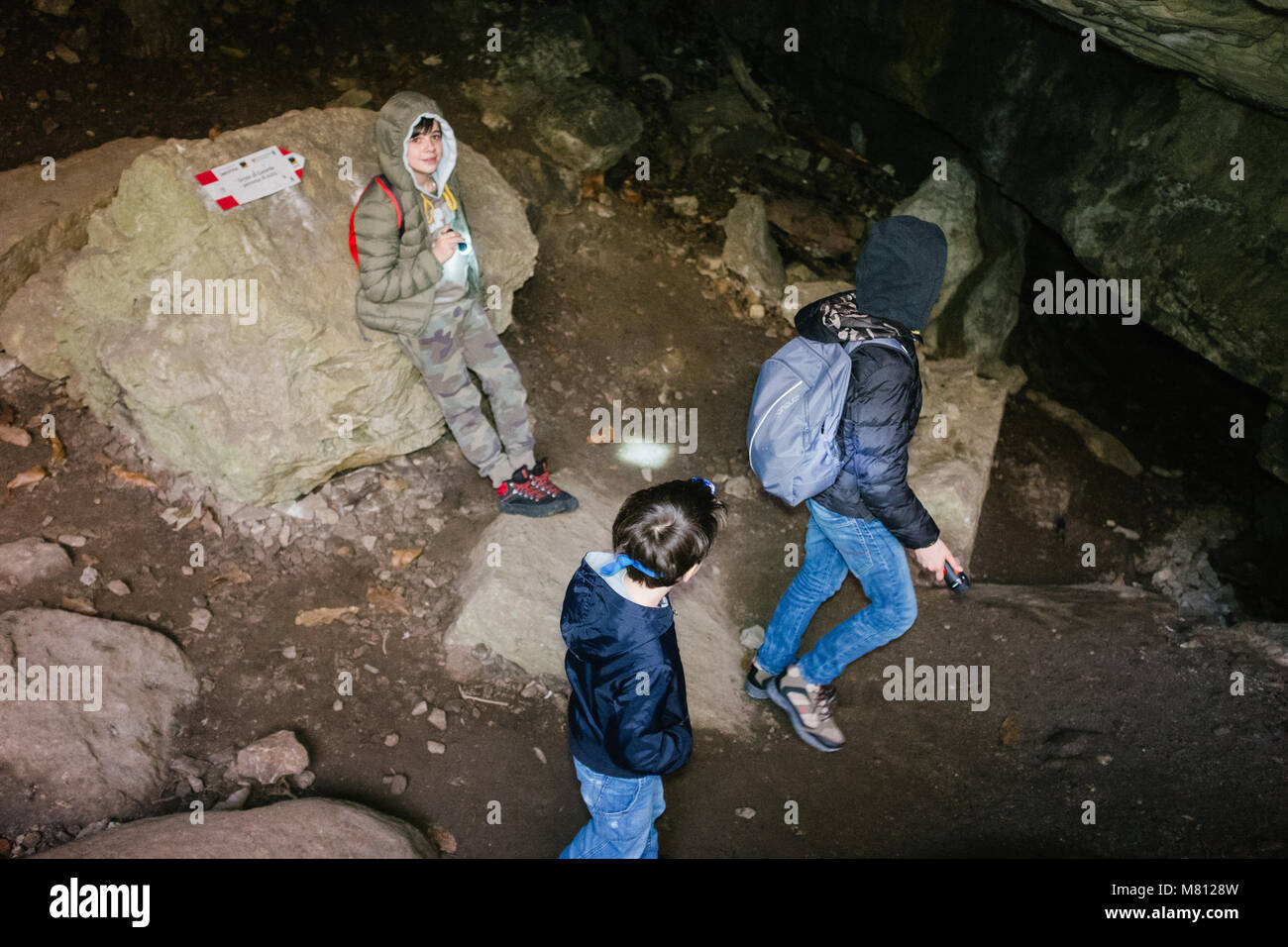 children explore underground caves, with electric torches exploring the ...